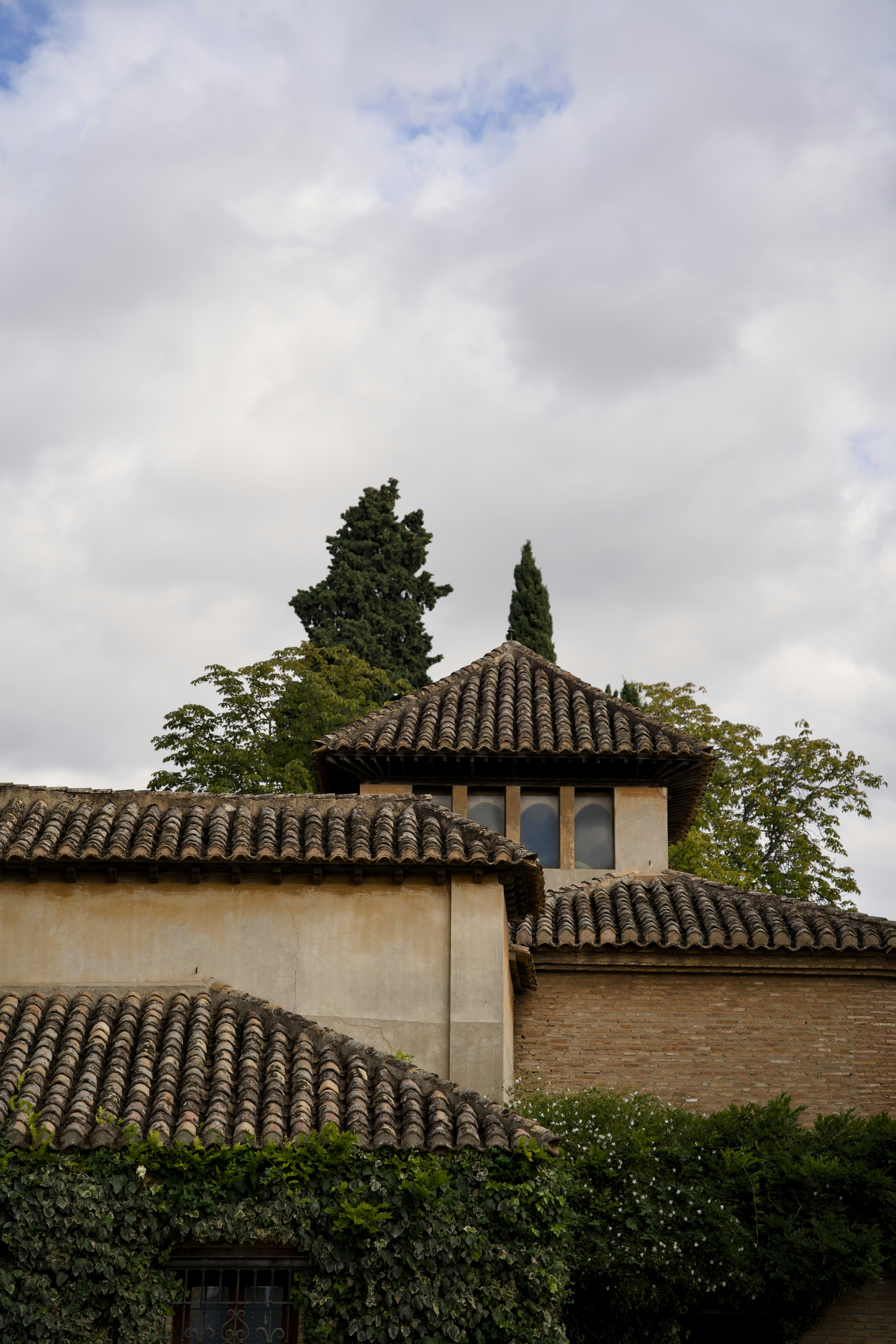 Terracotta Roofs and Quiet Courtyard Under a Sky of Soft Clouds