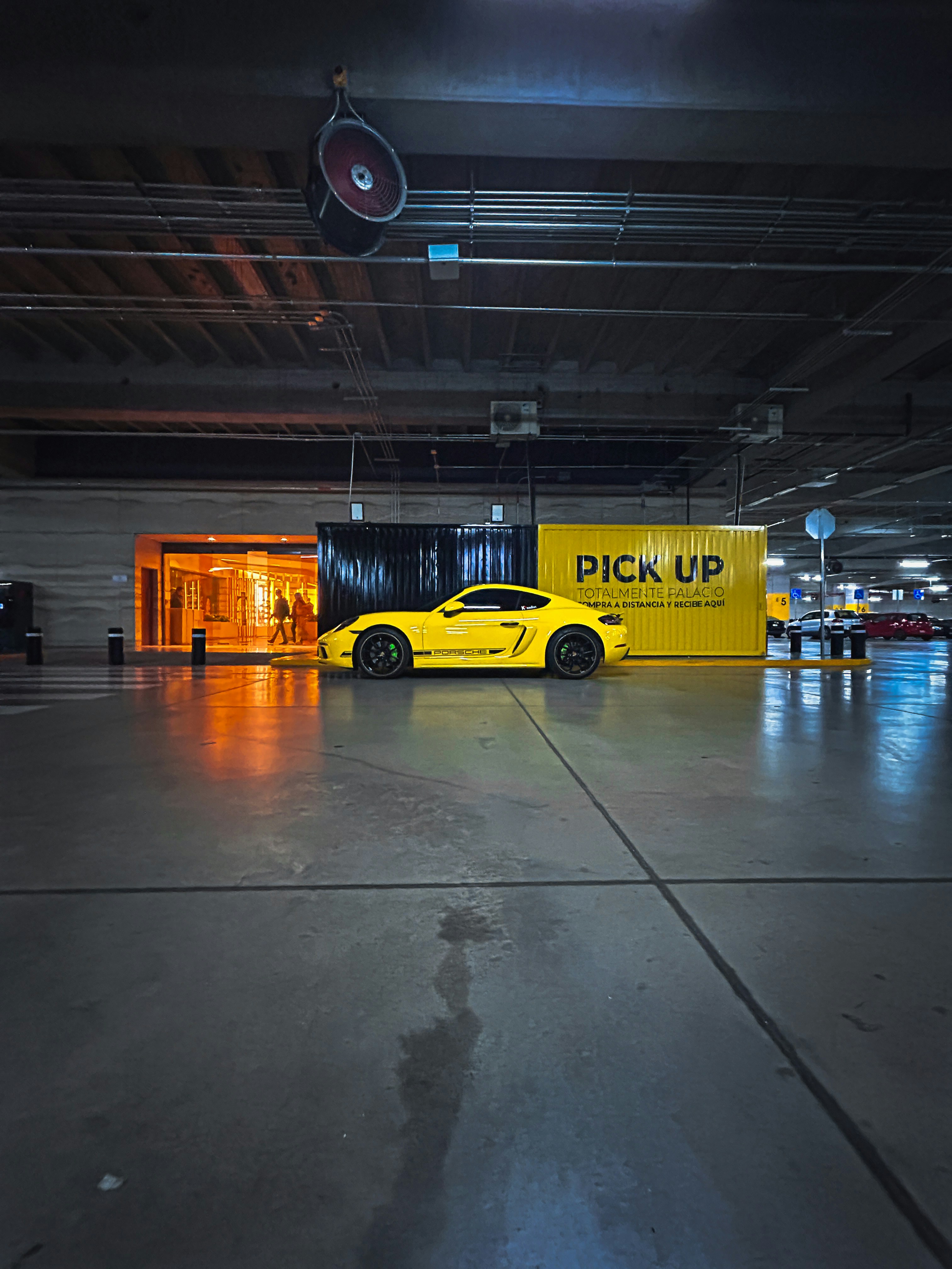 Yellow Ferrari in a Dim Parking Garage under Industrial Ceiling Lights