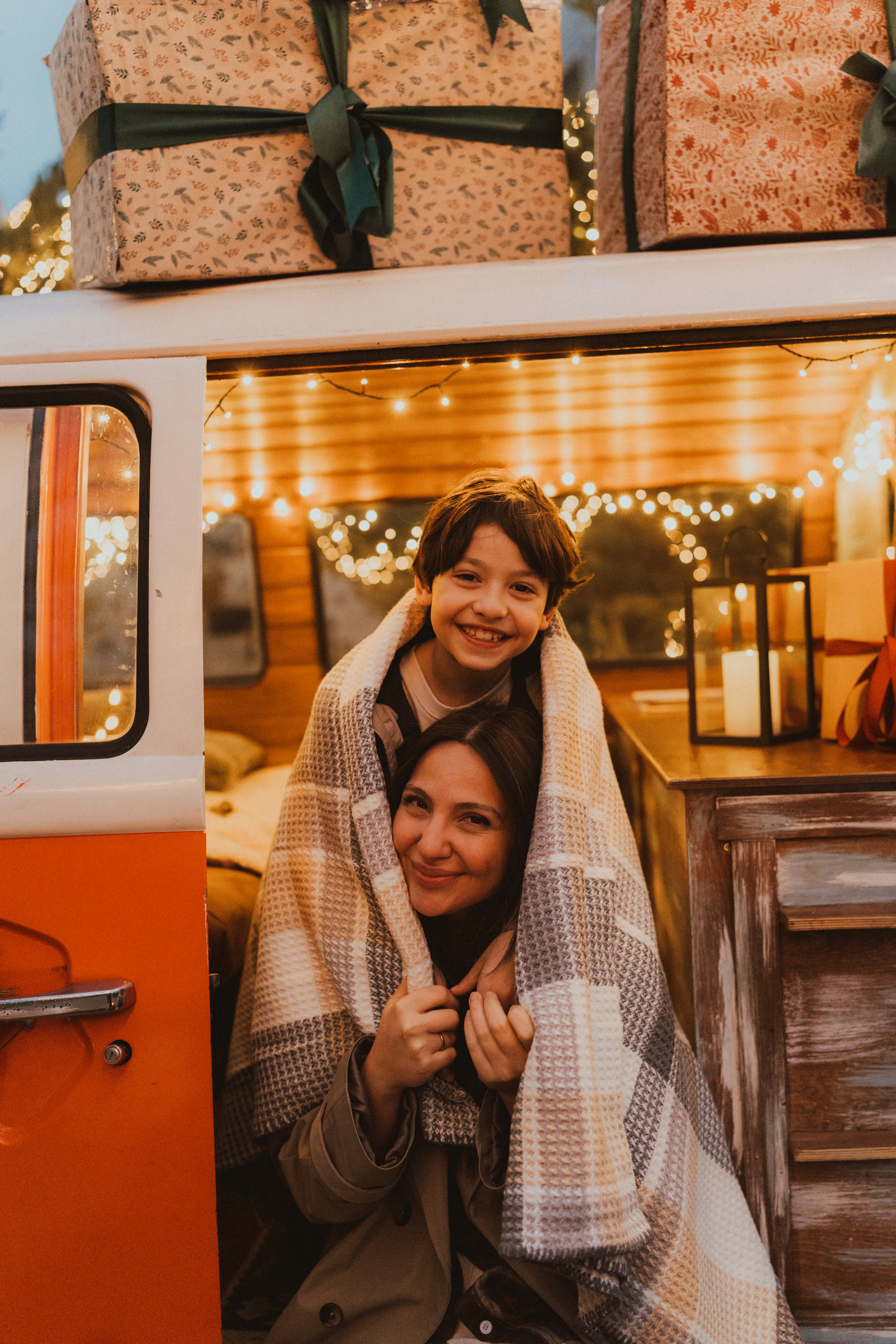 Cozy Carousel of Warmth: A Mother and Child Wrapped in Holiday Light Glow