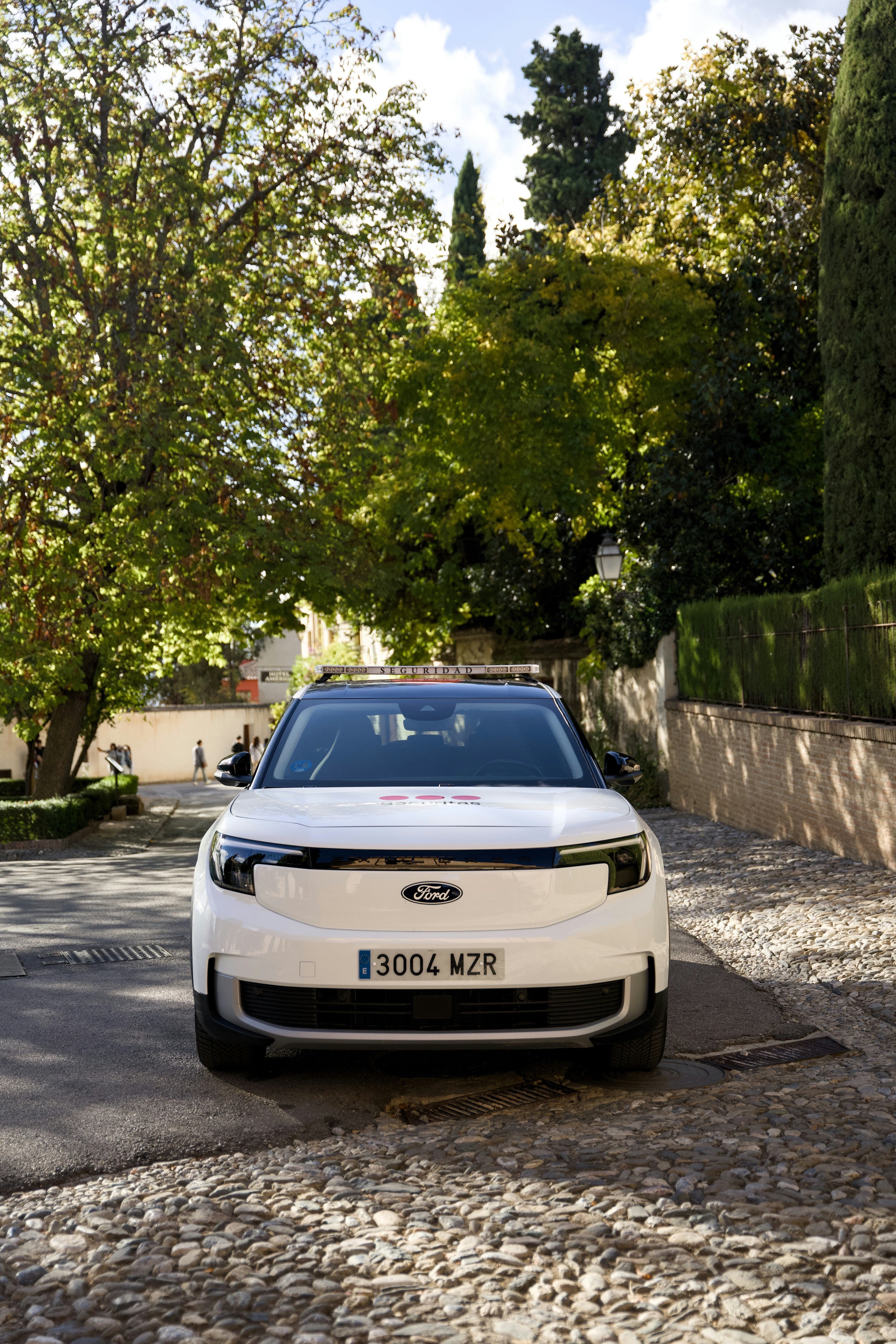 White Ford Utility in a Sunlit Cobblestone Courtyard