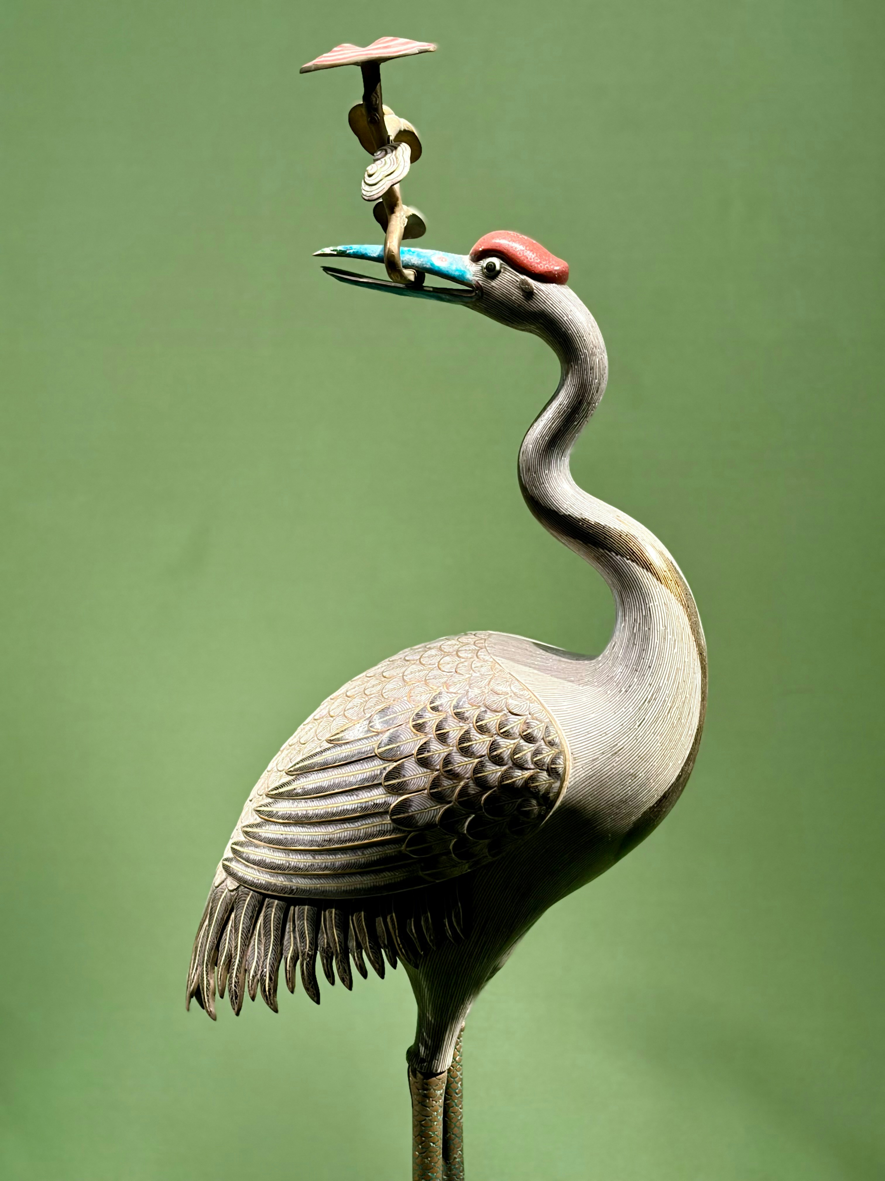 Crane sculpture with a figure balancing on its beak