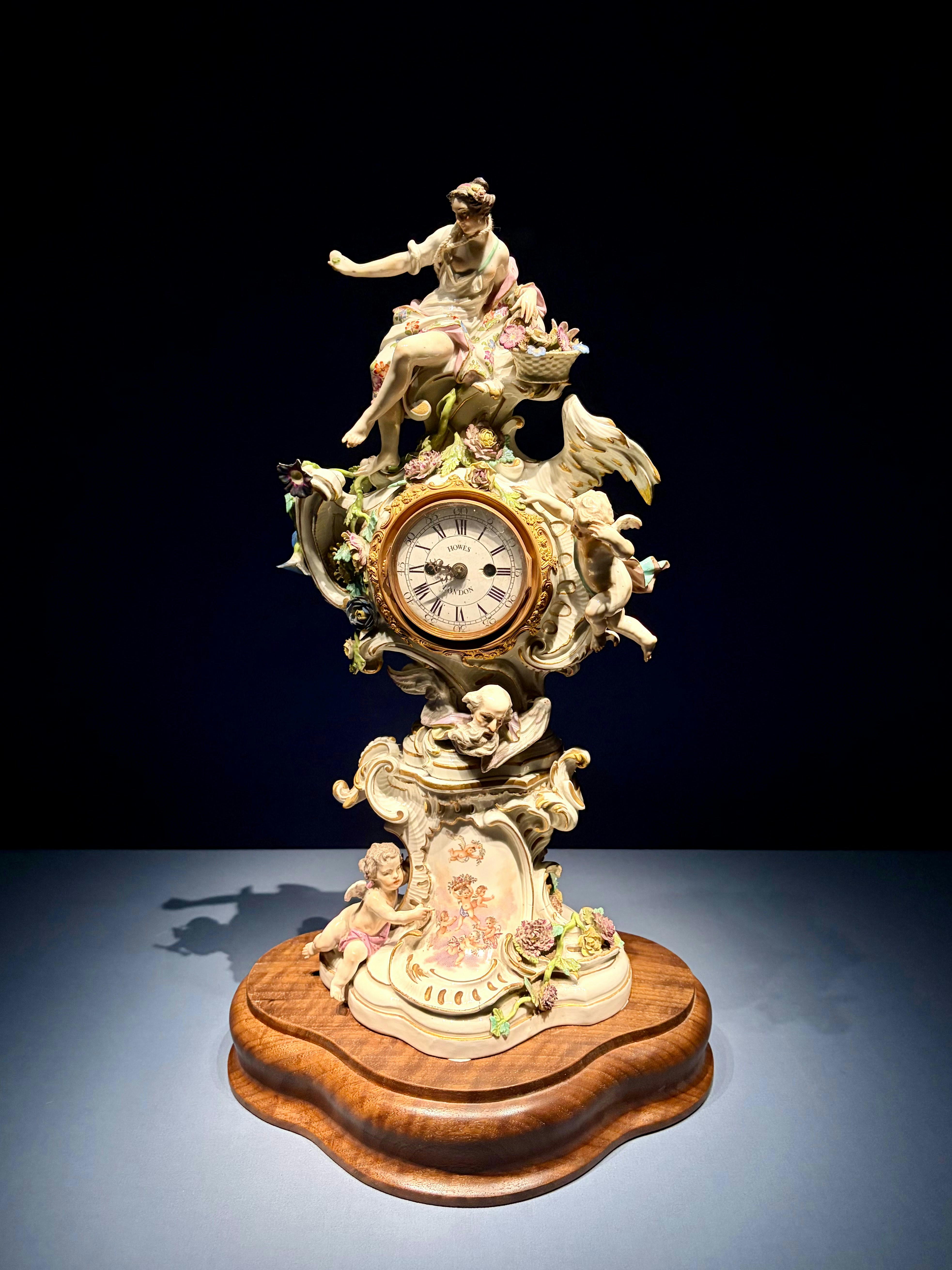 Ornate porcelain mantel clock with cherubs and figures.