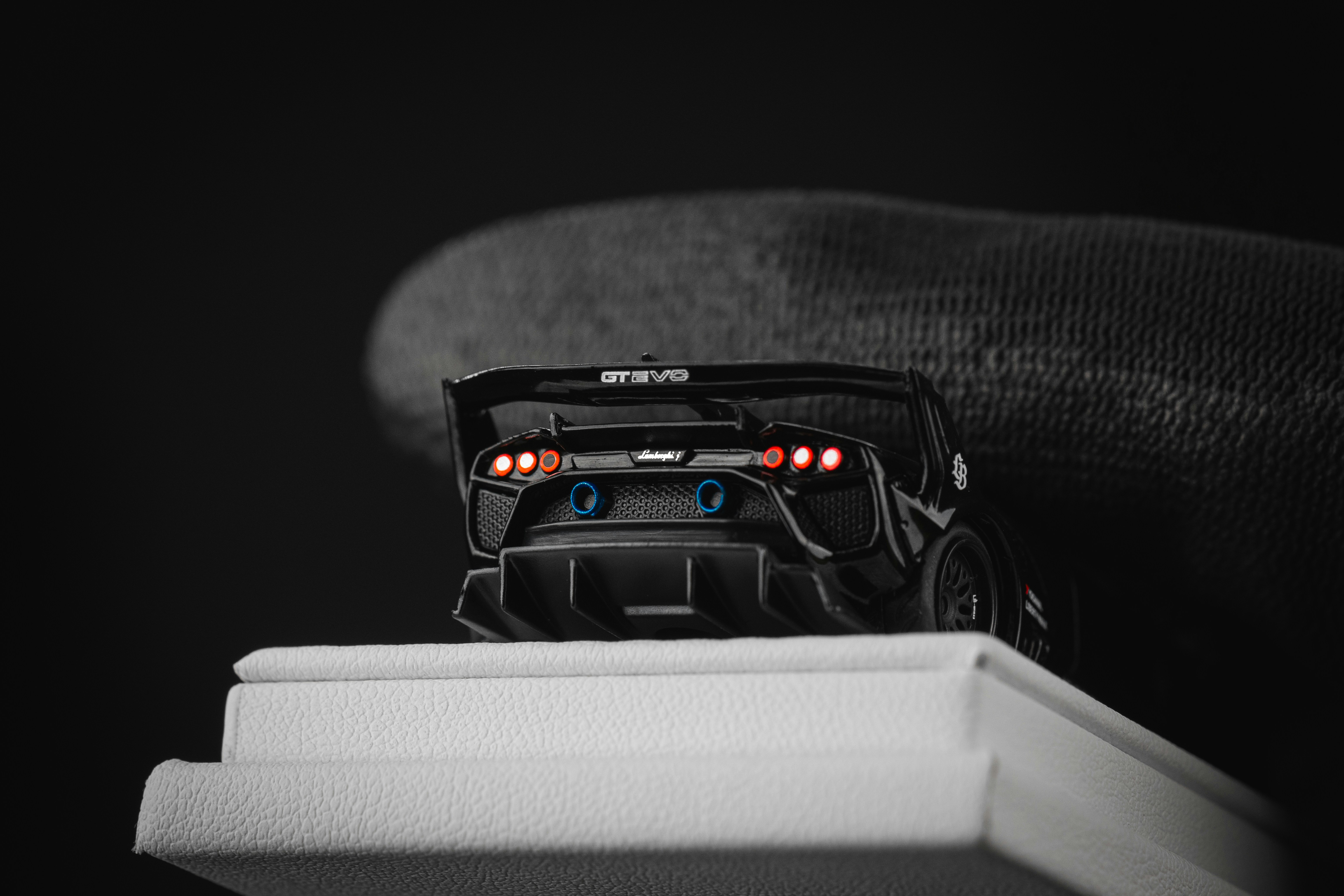 Rear View in Black and White: A toy racecar perches atop a foam stair
