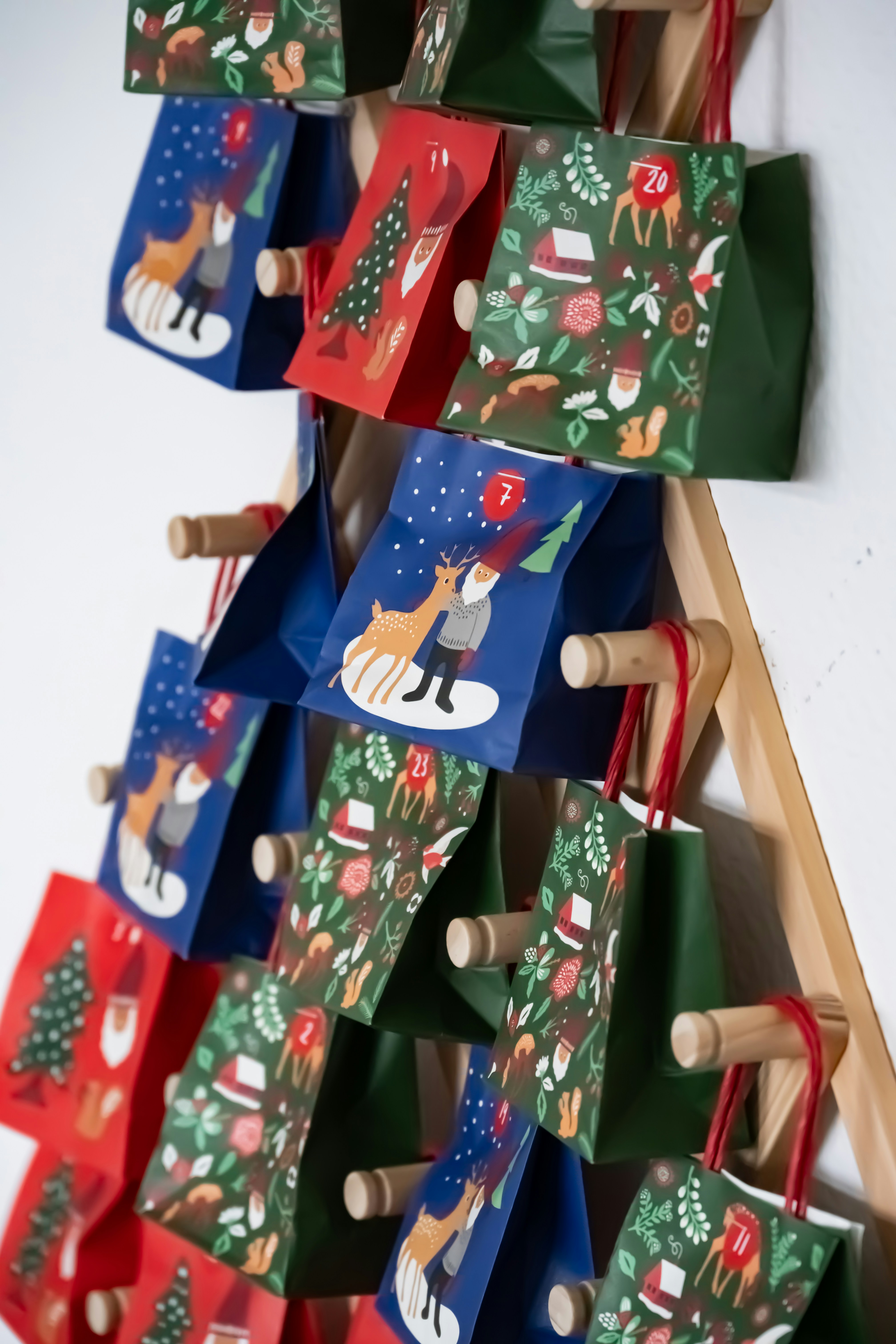 Strings of Joy: A Cascade of Holiday Gift Bags on a Wooden Rack