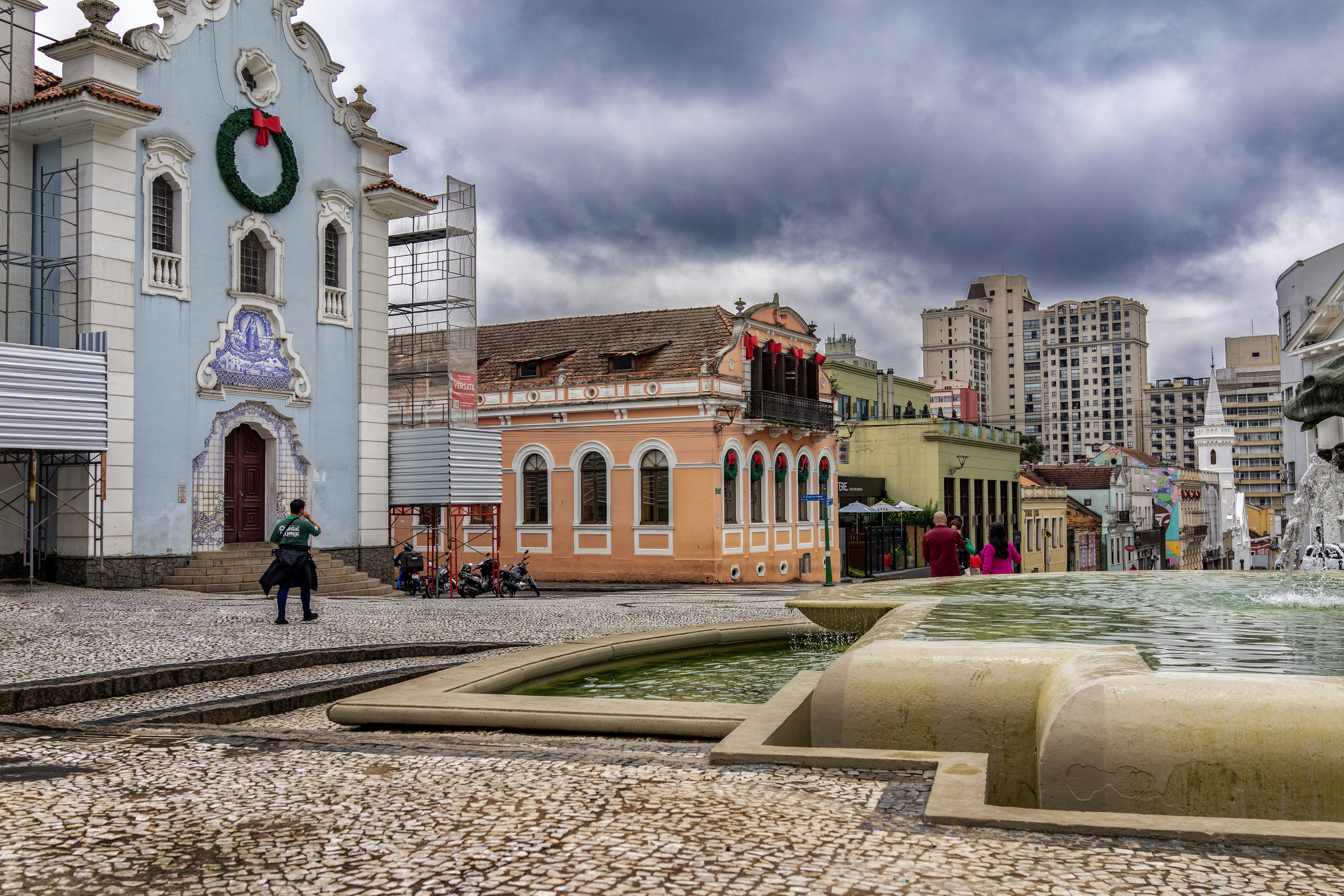 Pastel Plaza: Crescent-Wabled Facades Beneath Dramatic Skies