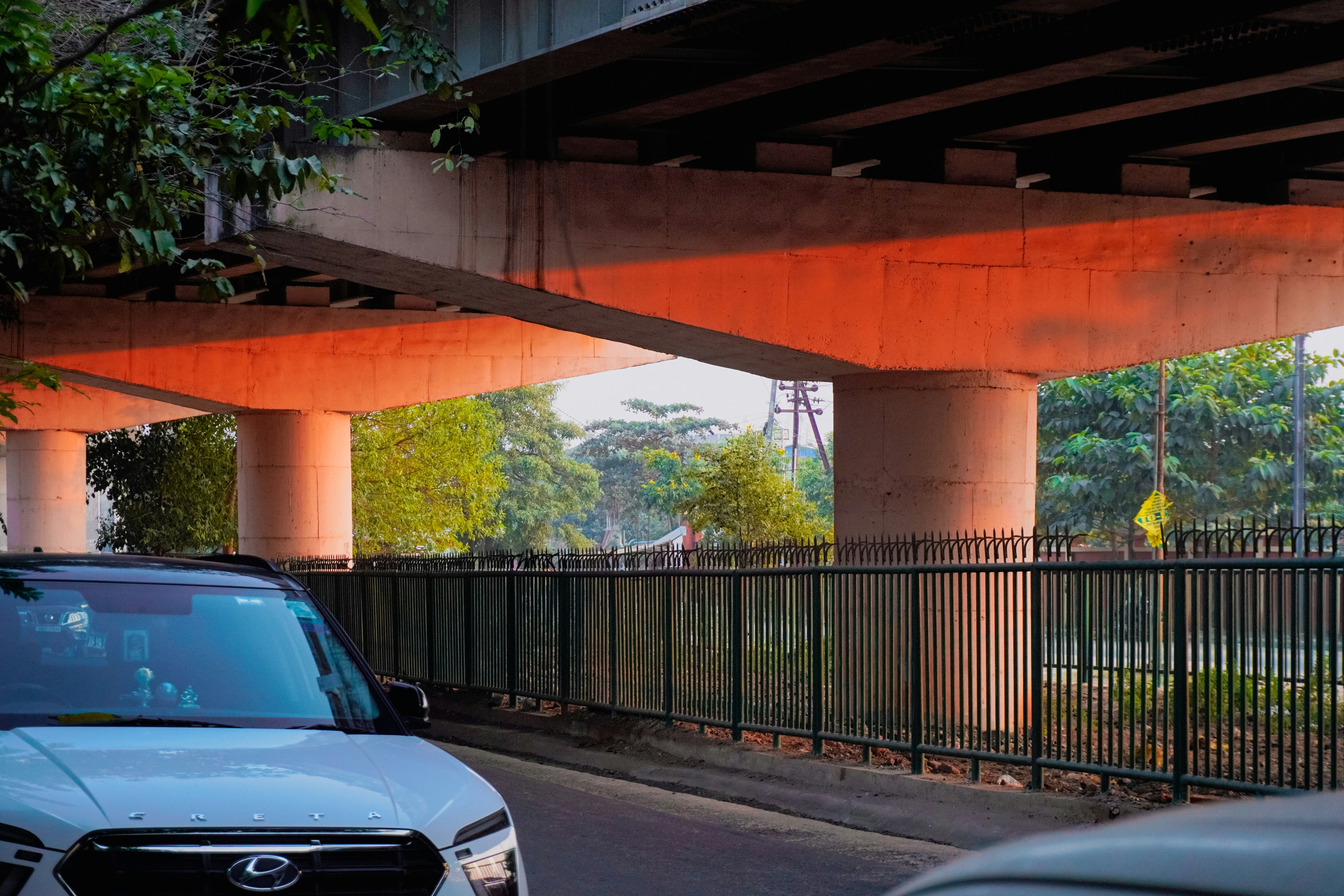 Underpass Quiet: A White SUV Pauses beside the Bridge Pillar