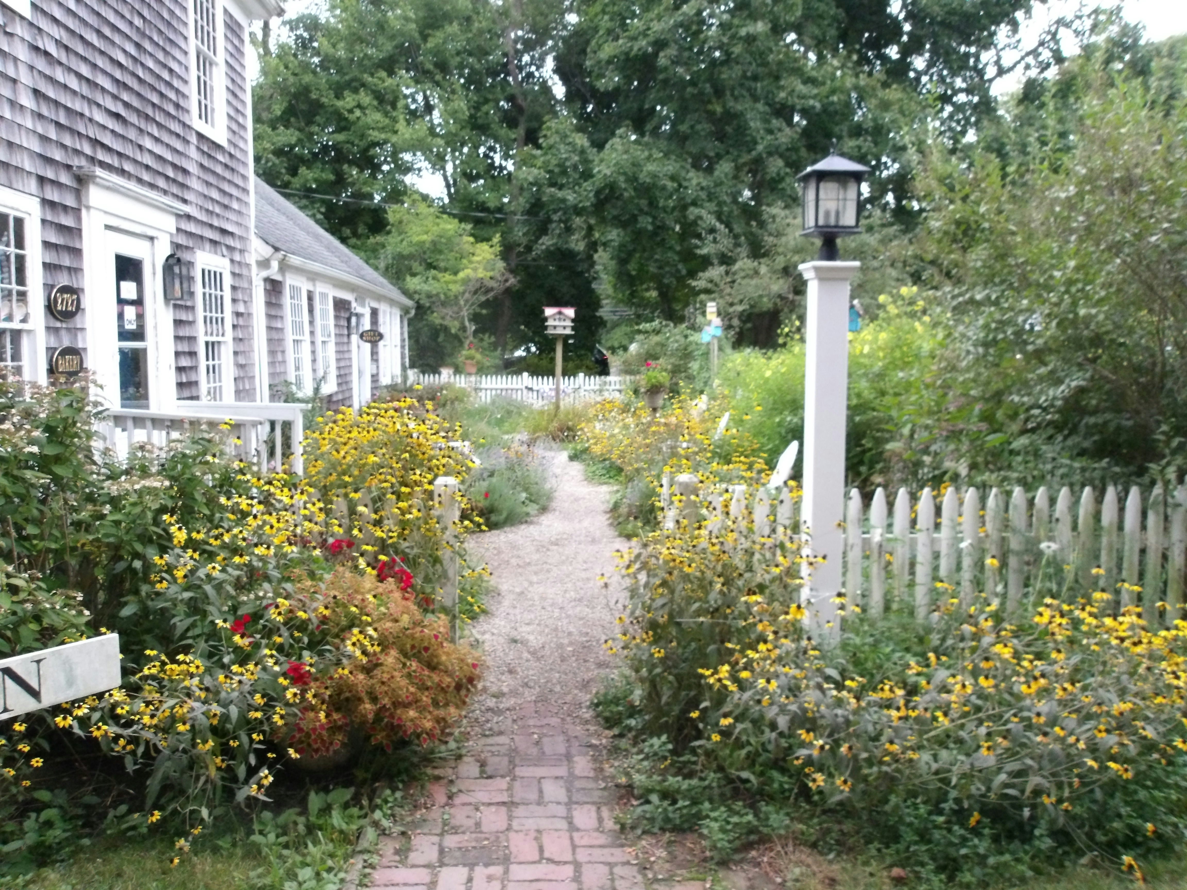 A brick path leads through a garden with flowers. photo – Free Flower ...