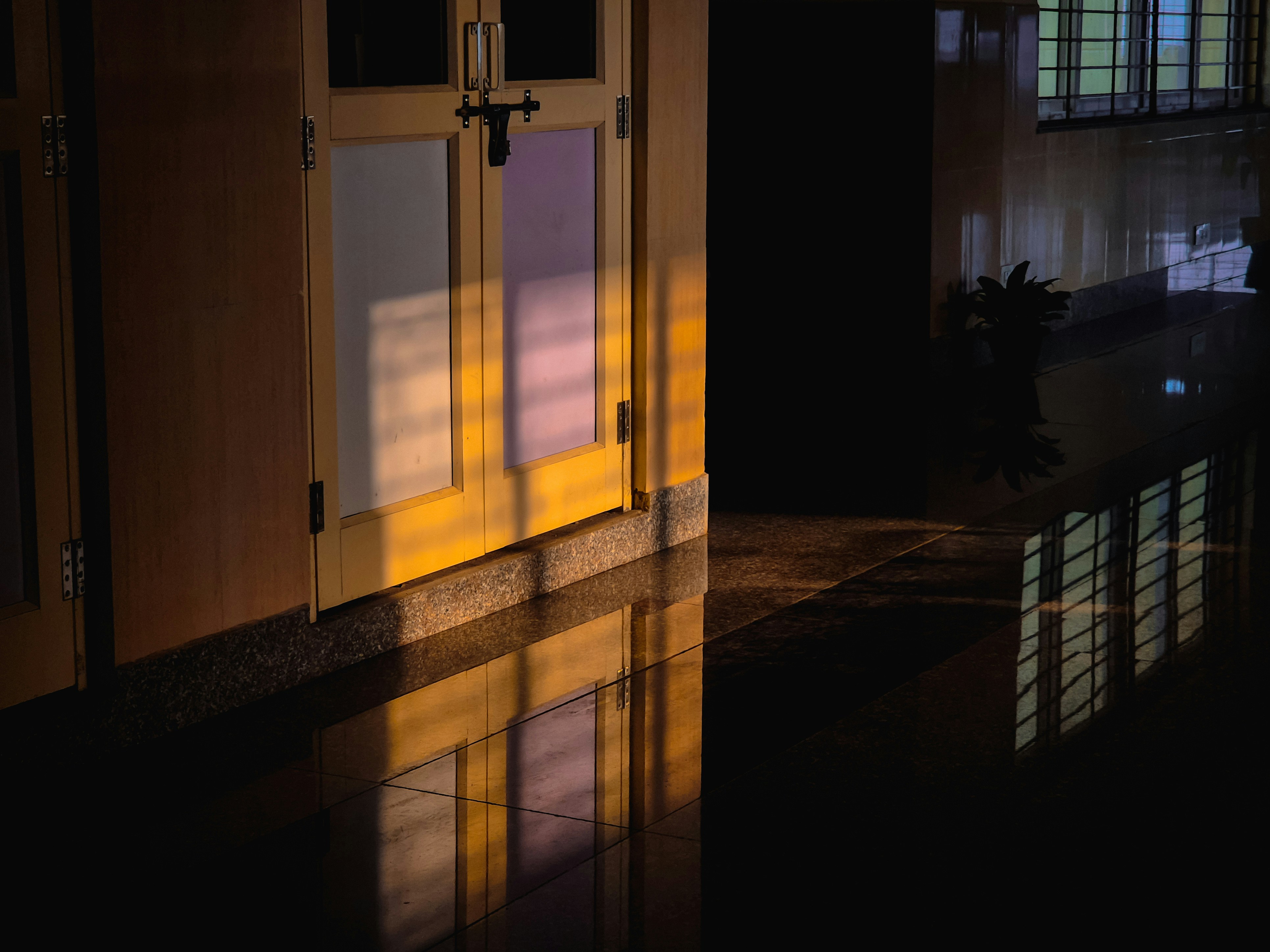 Sunlit Doors and Reflections in a Dim Corridor