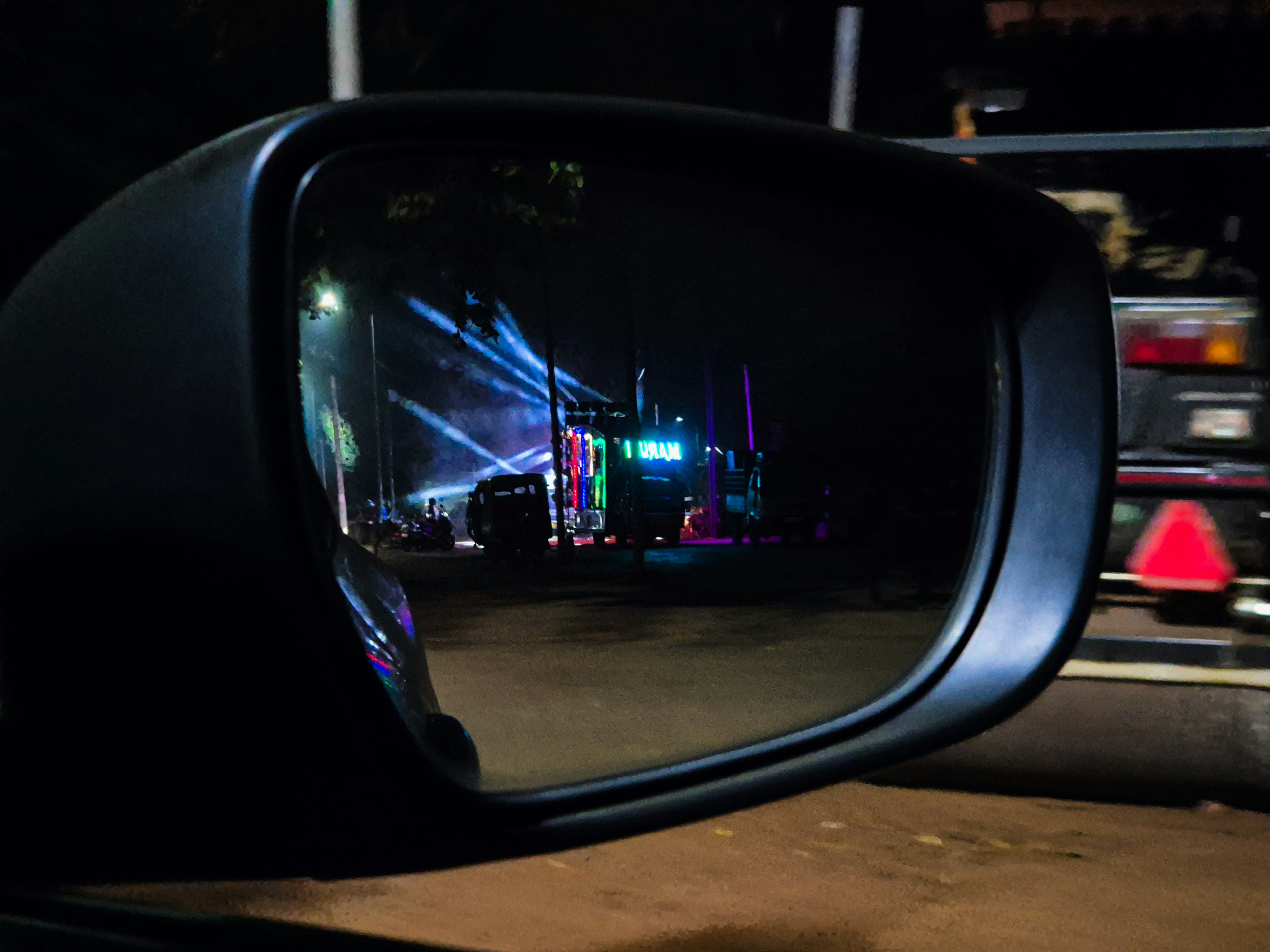 Reflections of a Nightstage: Neon Lights in the Side Mirror