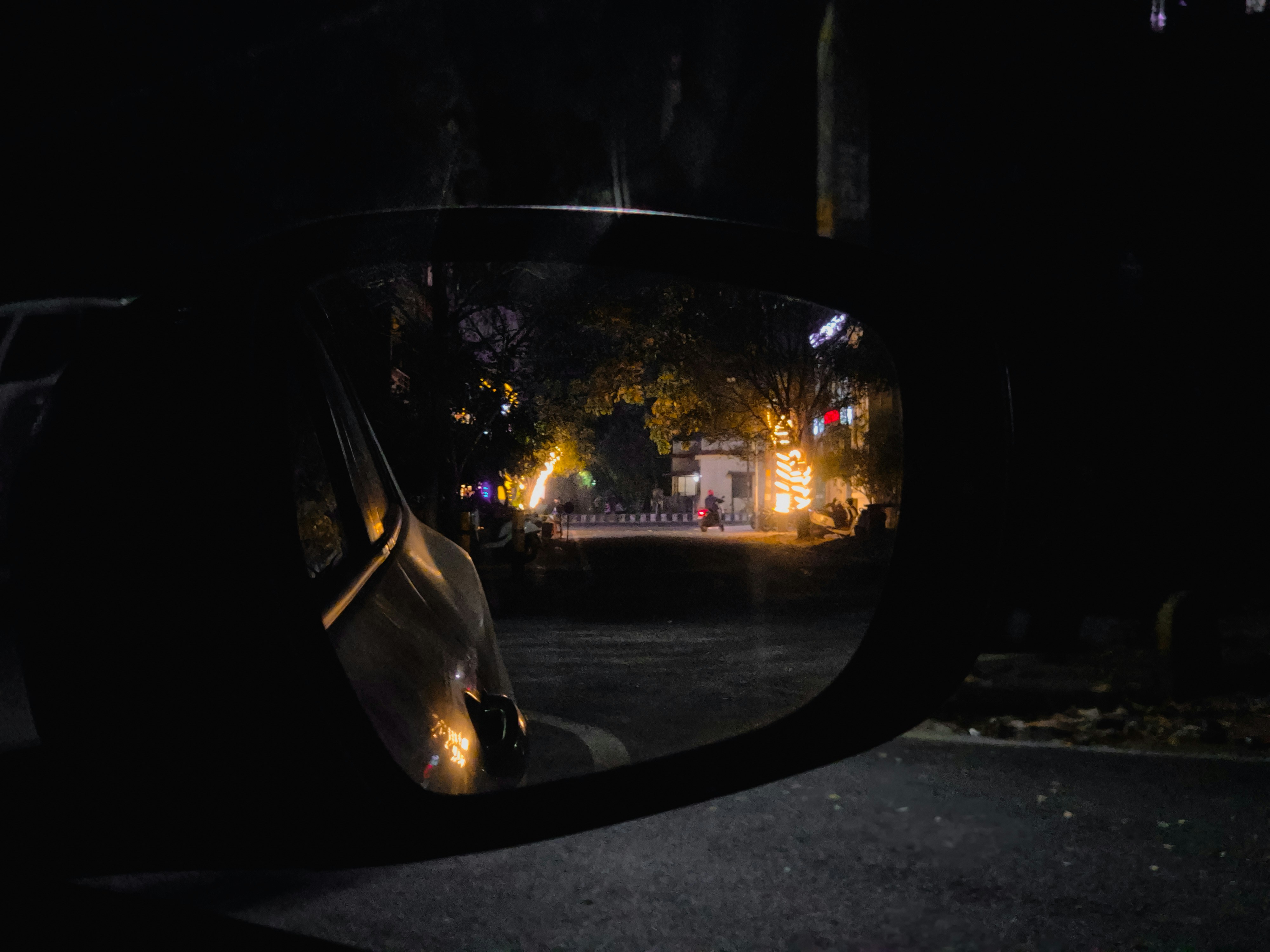 Rearview Mirror Night Scene: Street Lights Framing a Quiet Street