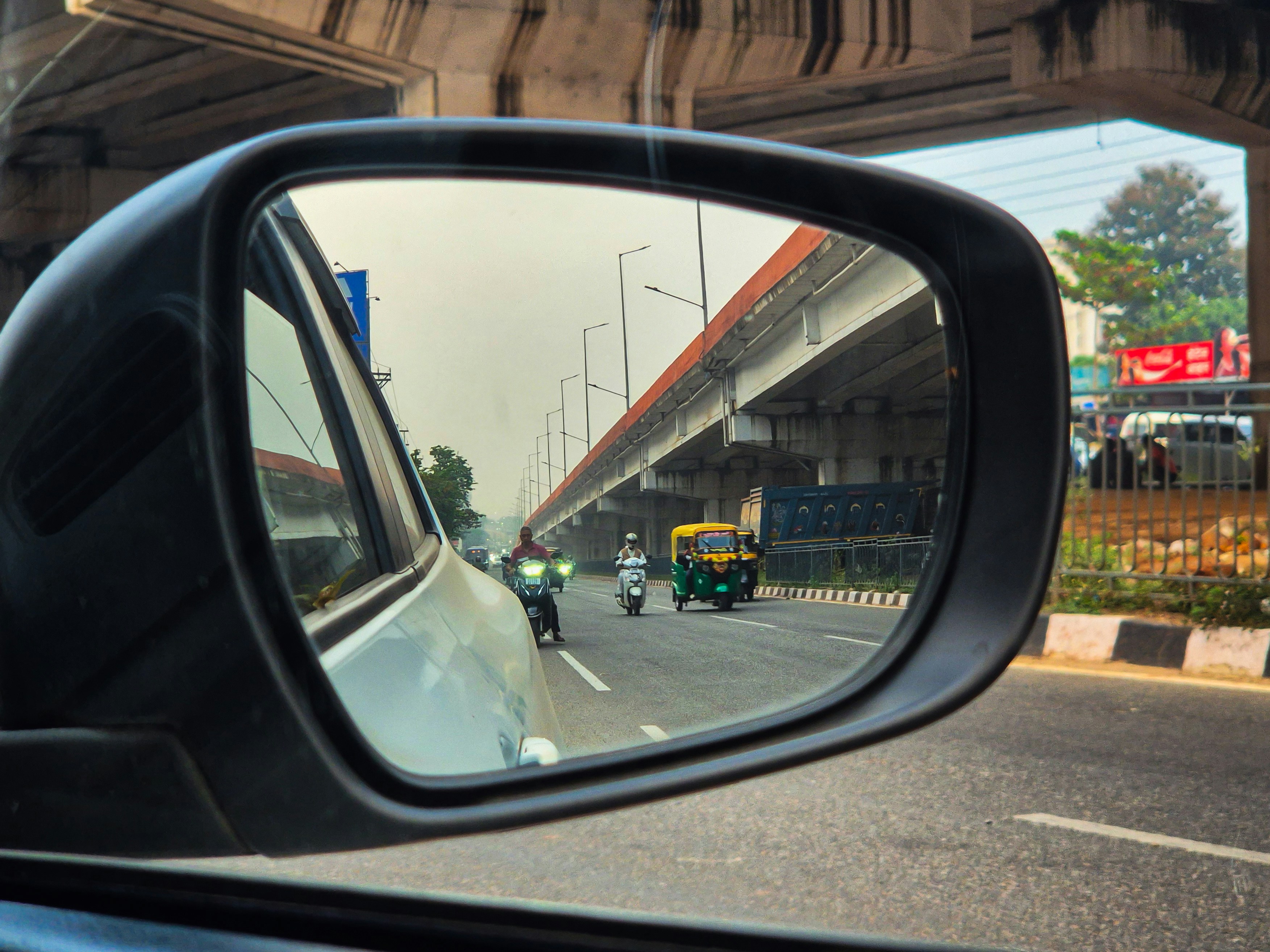 Side-View Mirror Perspective: Street Scene in Transit