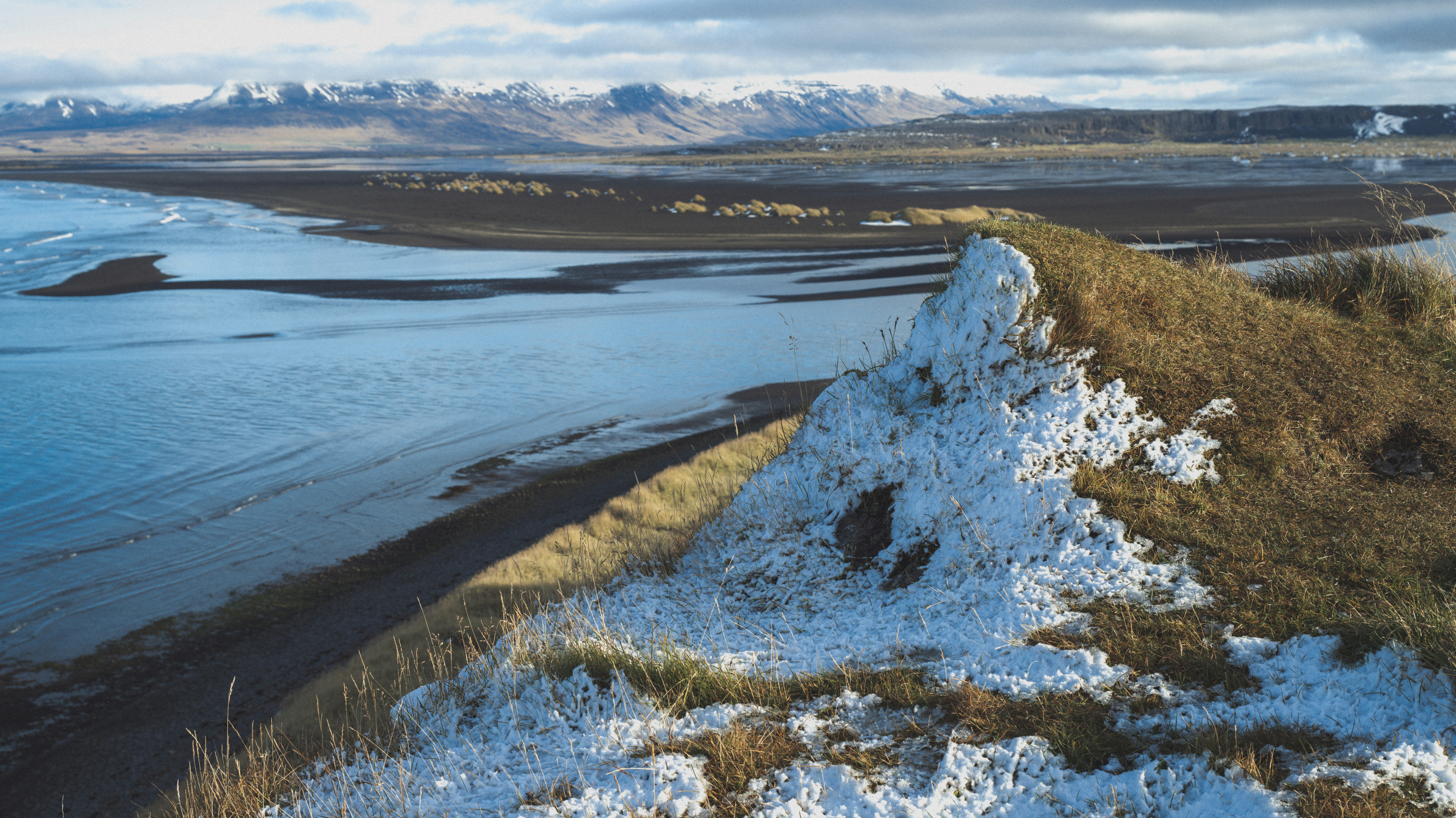 Cliff Edge Blanket: Snow, Grass, and a Quiet Continent of Shore