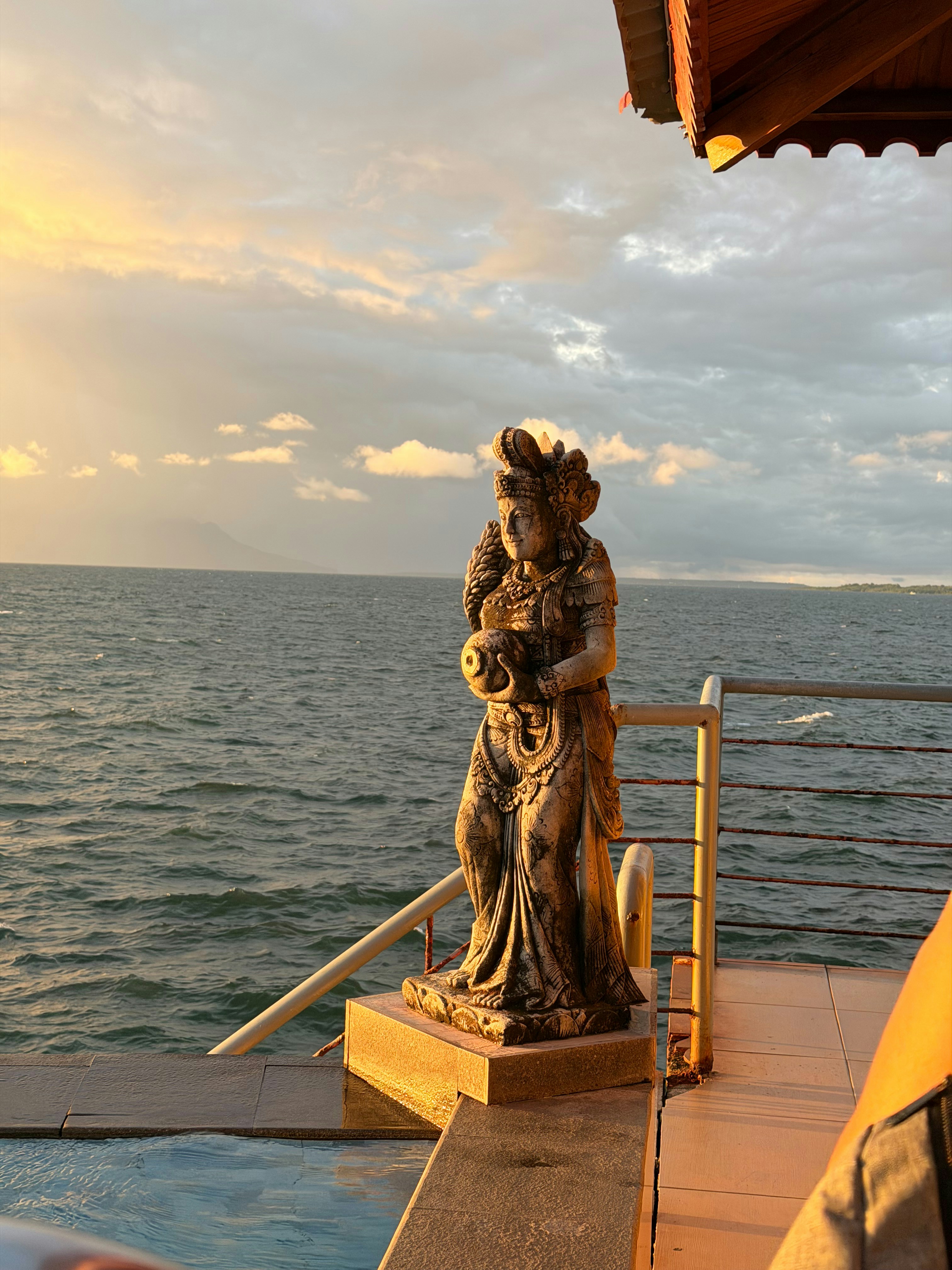 Statue at the Sunset Pier: Guardian of the Ocean Vista