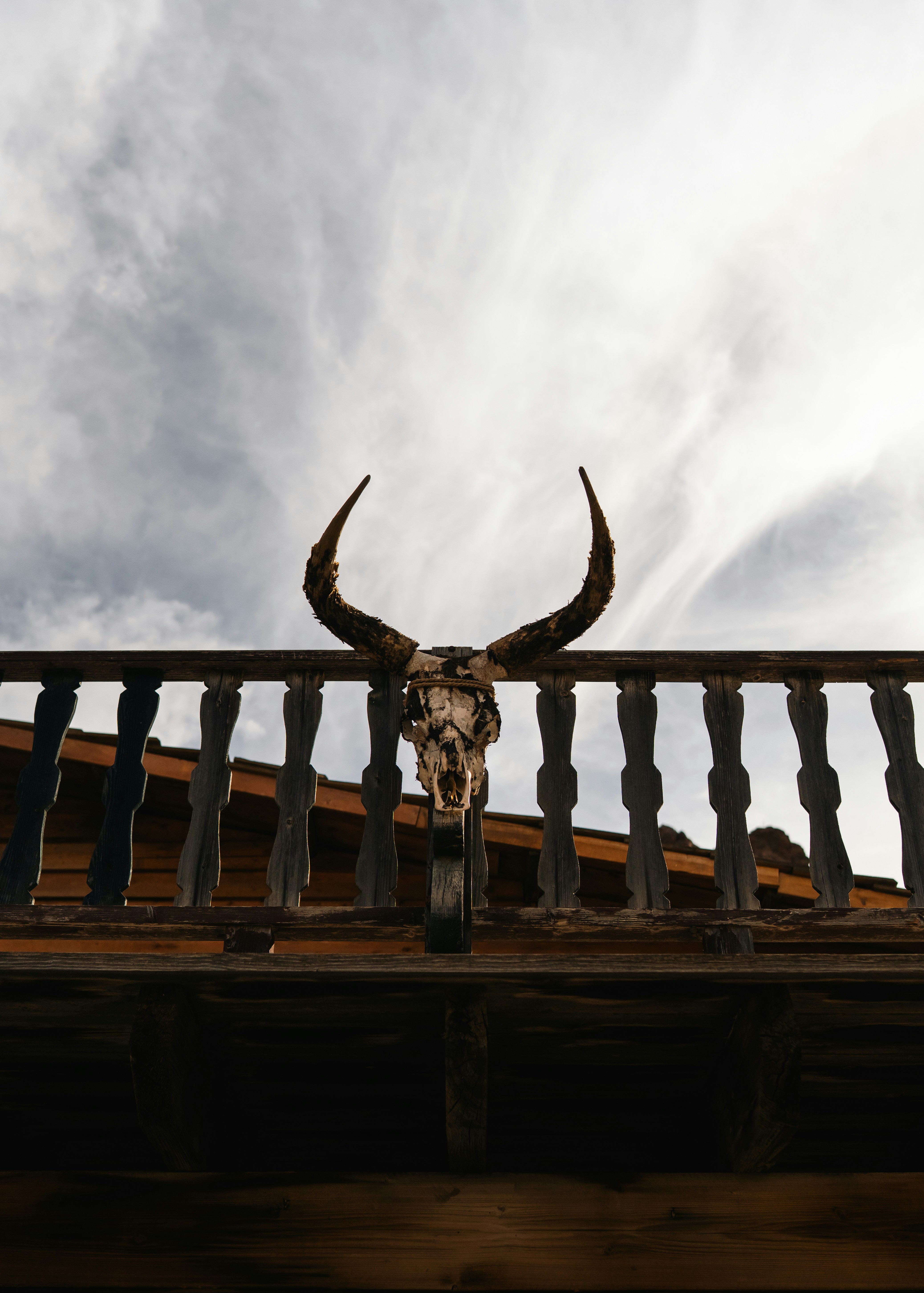 Horned Skull Crowned Balcony: Weathered Rails Guard a Rustic Roof