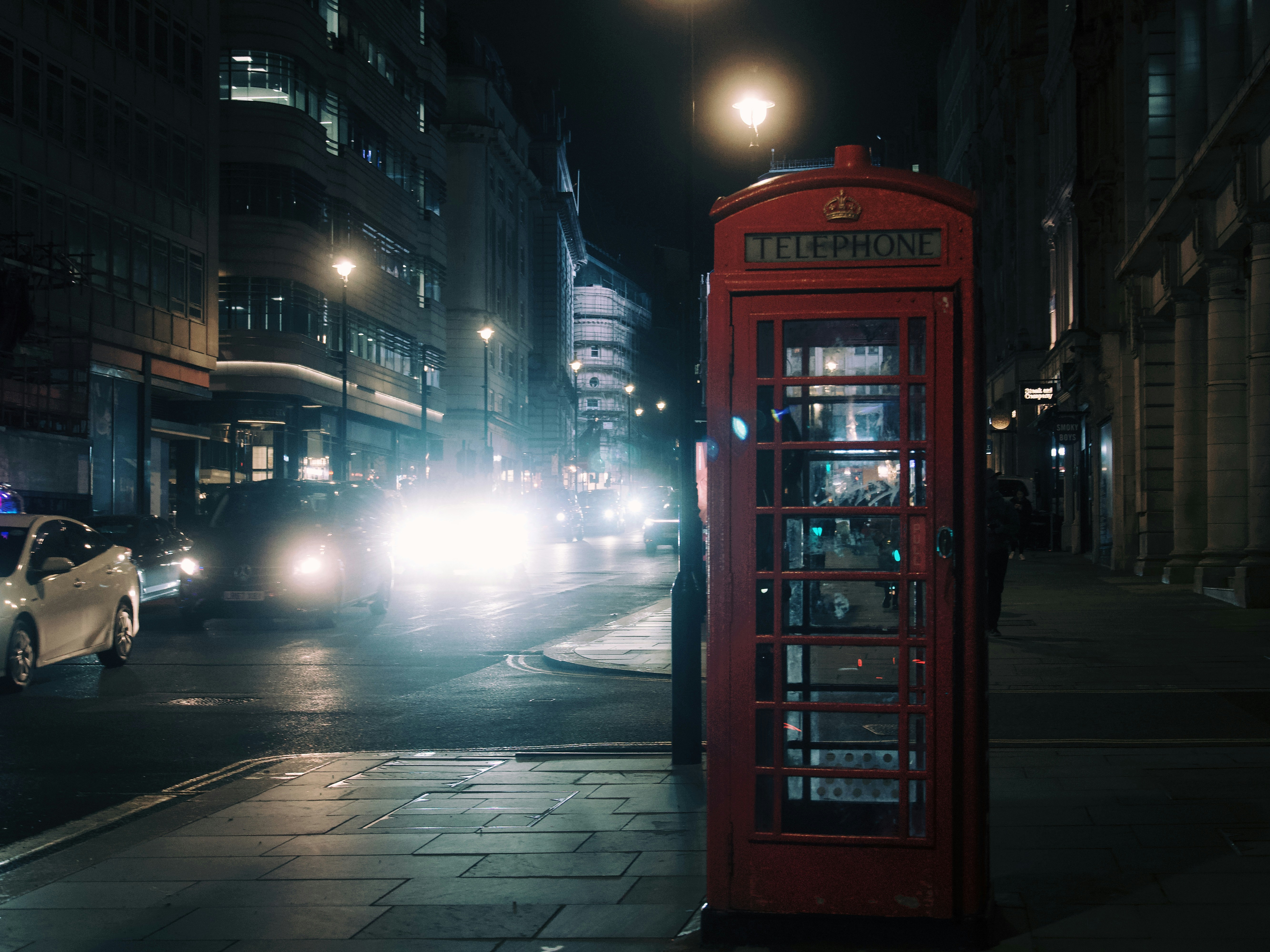 Red Phone Booth at Night: A Neon City Breathes Through a Quiet Street