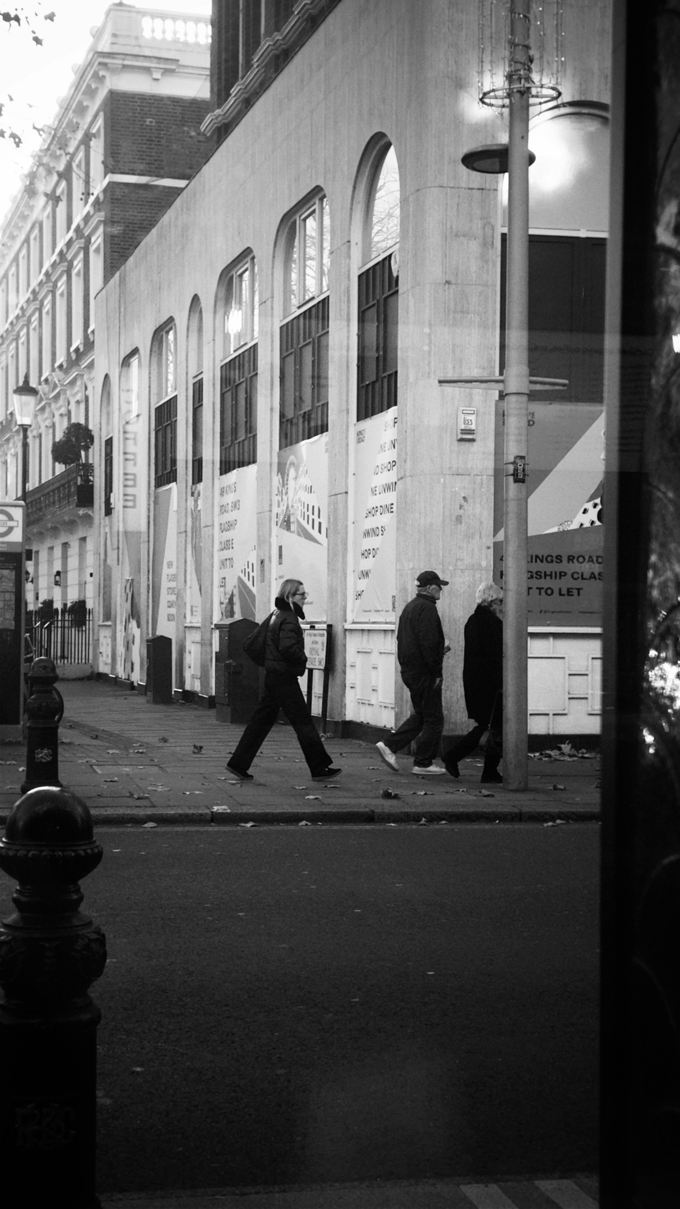 Passing Figures in Shadowed Arches