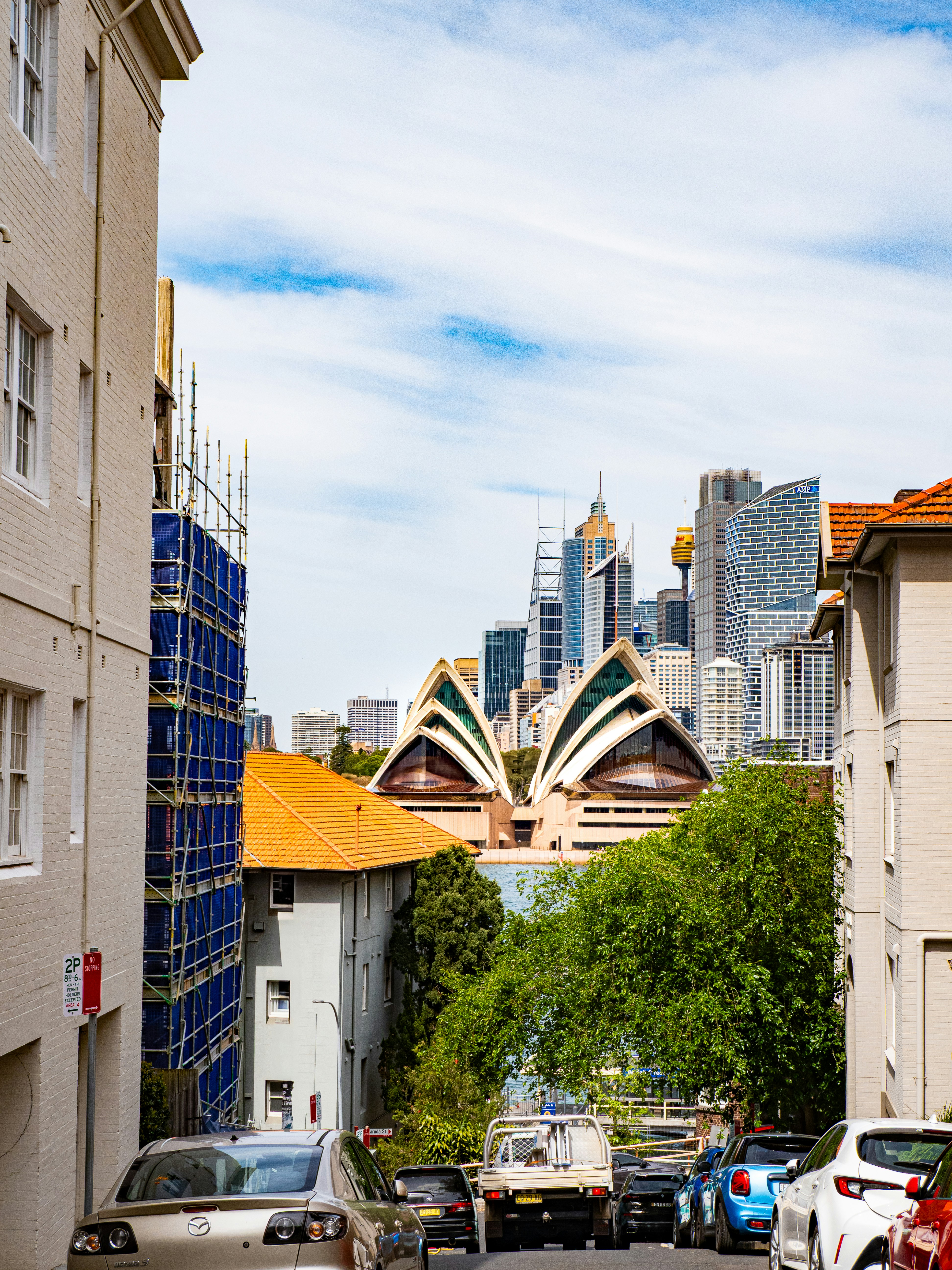 Sydney Opera House framed by a sunlit urban corridor
