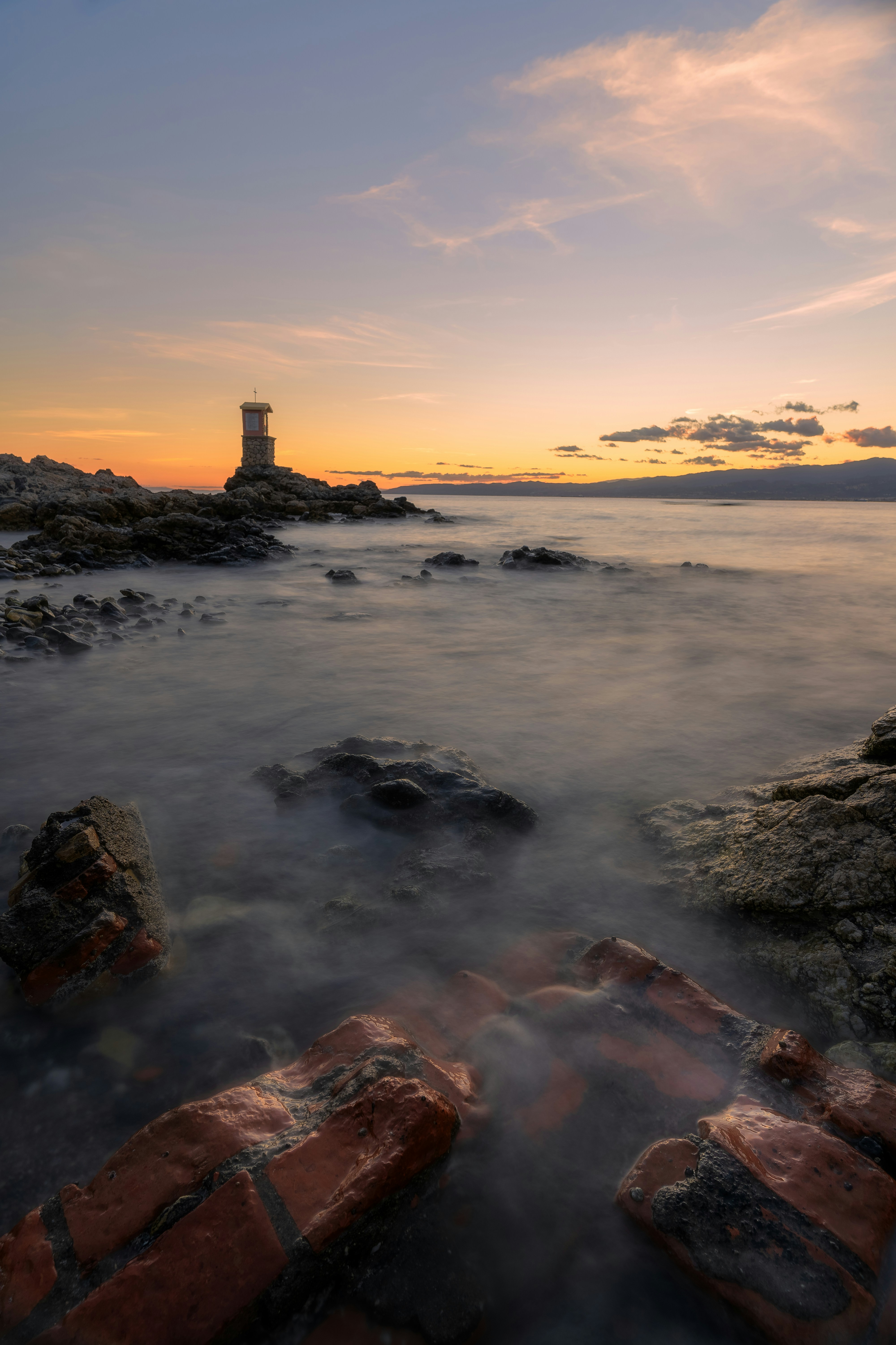 Sunset Beacon: A Lone Lighthouse hugging the rocky edge