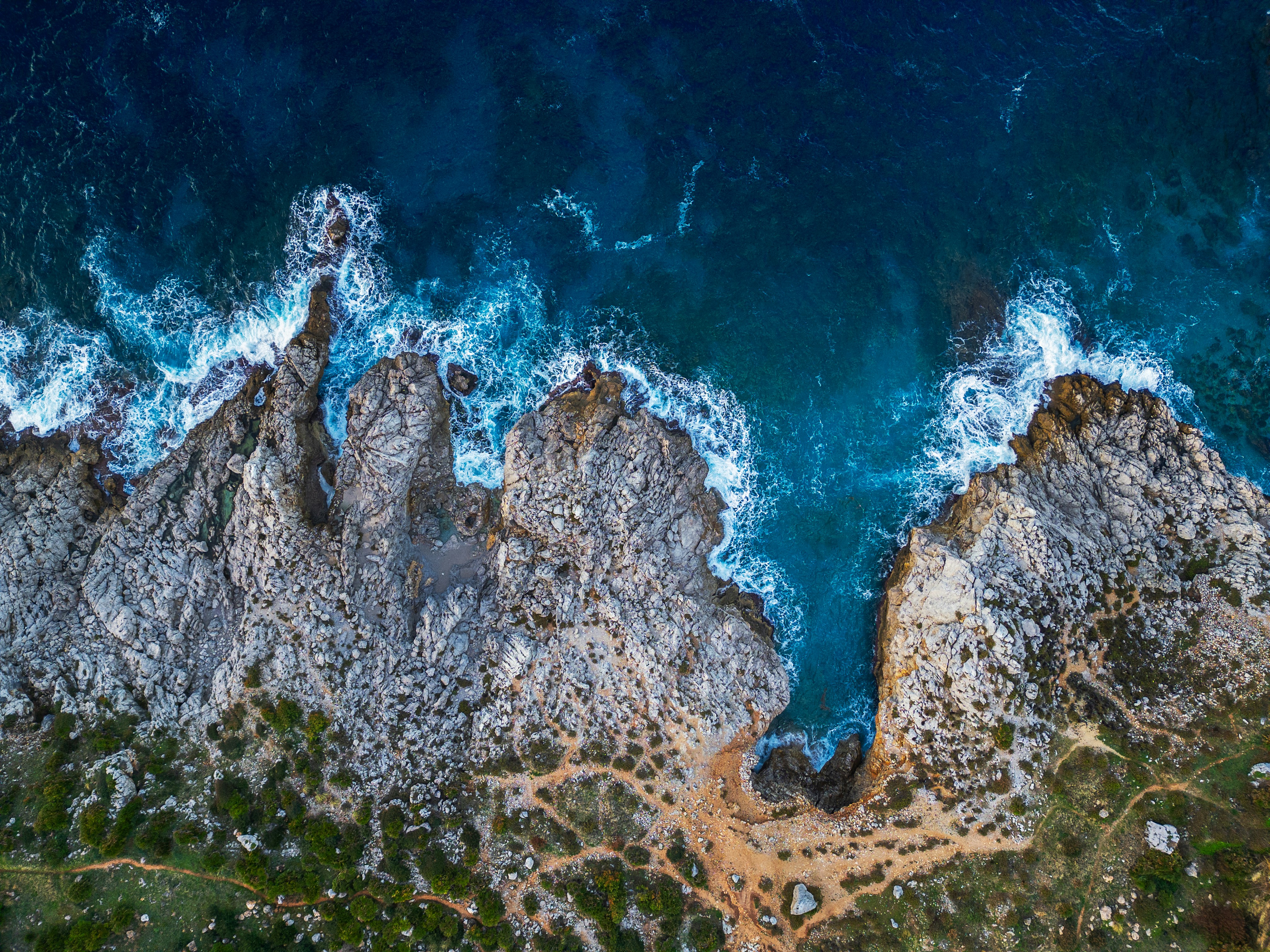 Coastal Vents: Aerial Portrait of Rocky Cove meeting Turquoise Waves