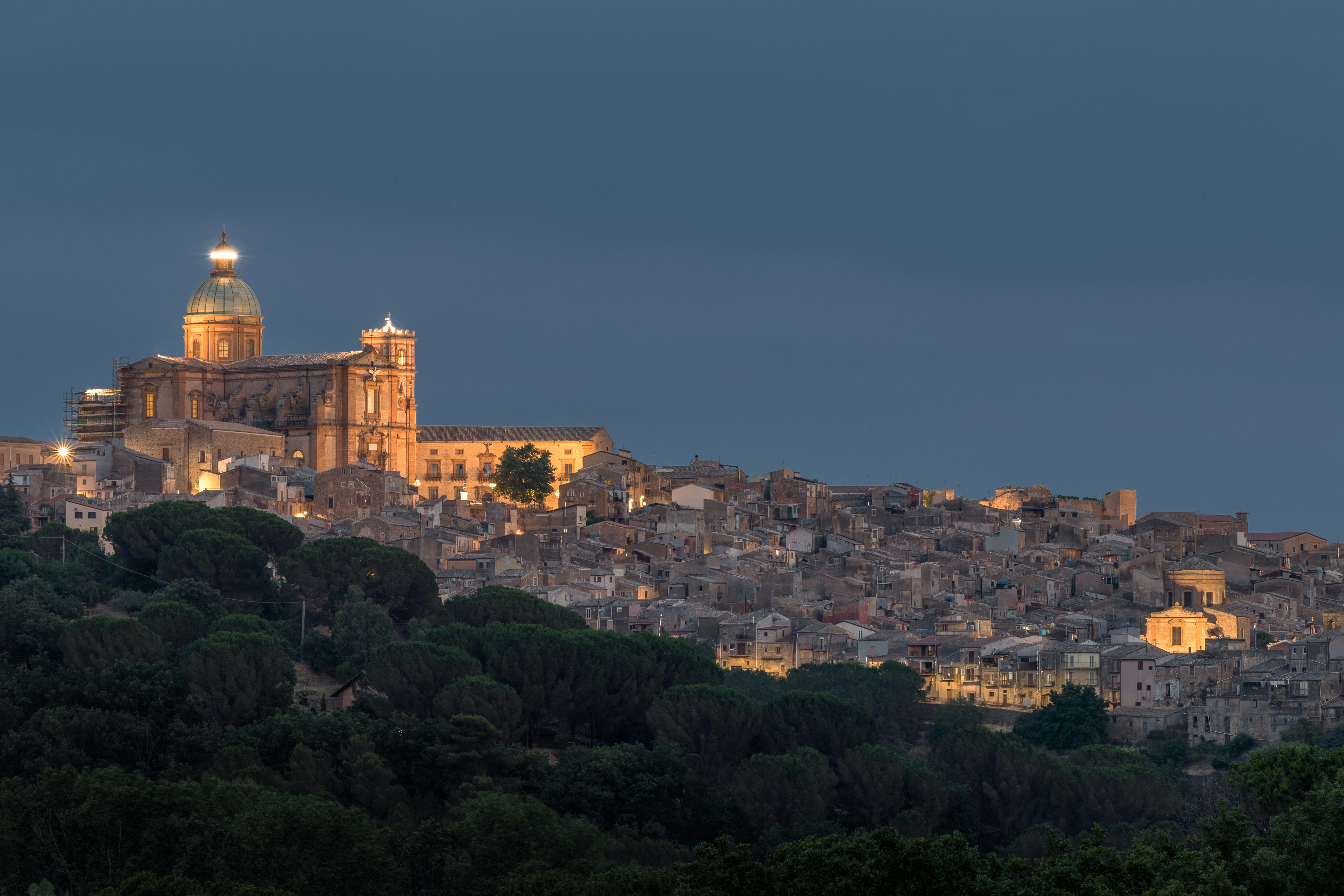 Golden Dome over Ligurian Hills: Evening Lights on a Historic Town