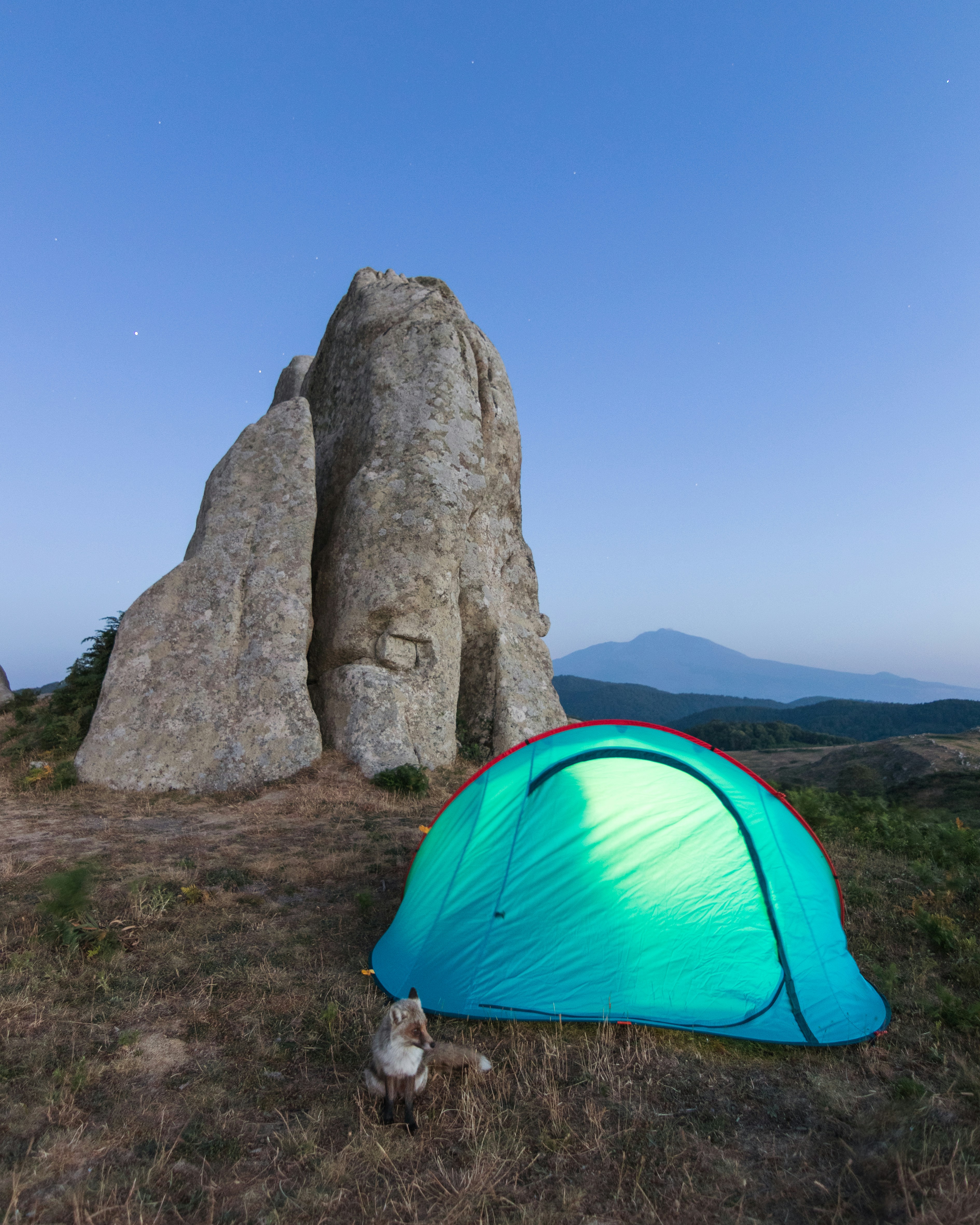 Twin Monoliths and a Teal Tent Under a Quiet Sky