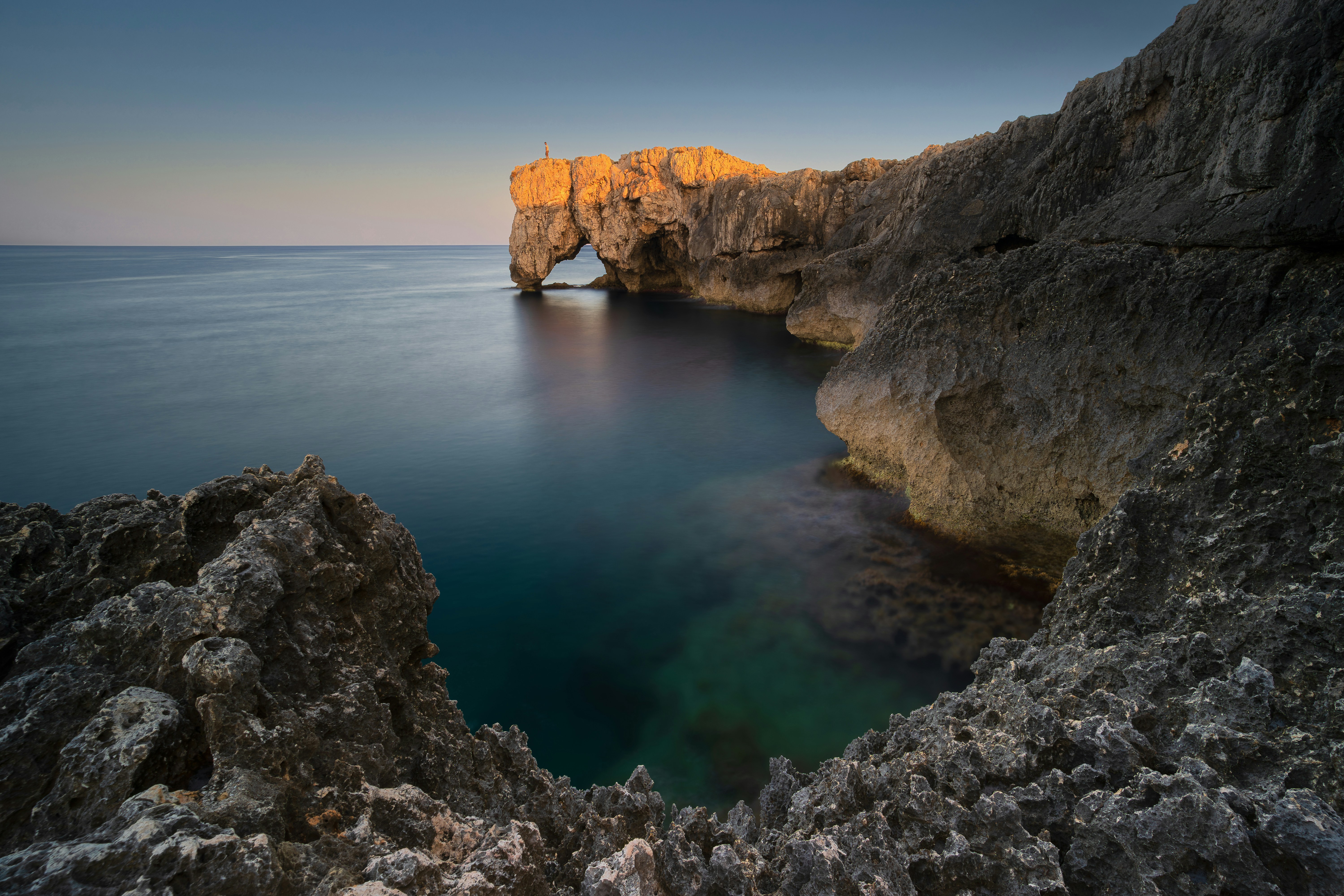 Sunlit Arch over Quiet Sea: A Coastal Portrait at Golden Hour