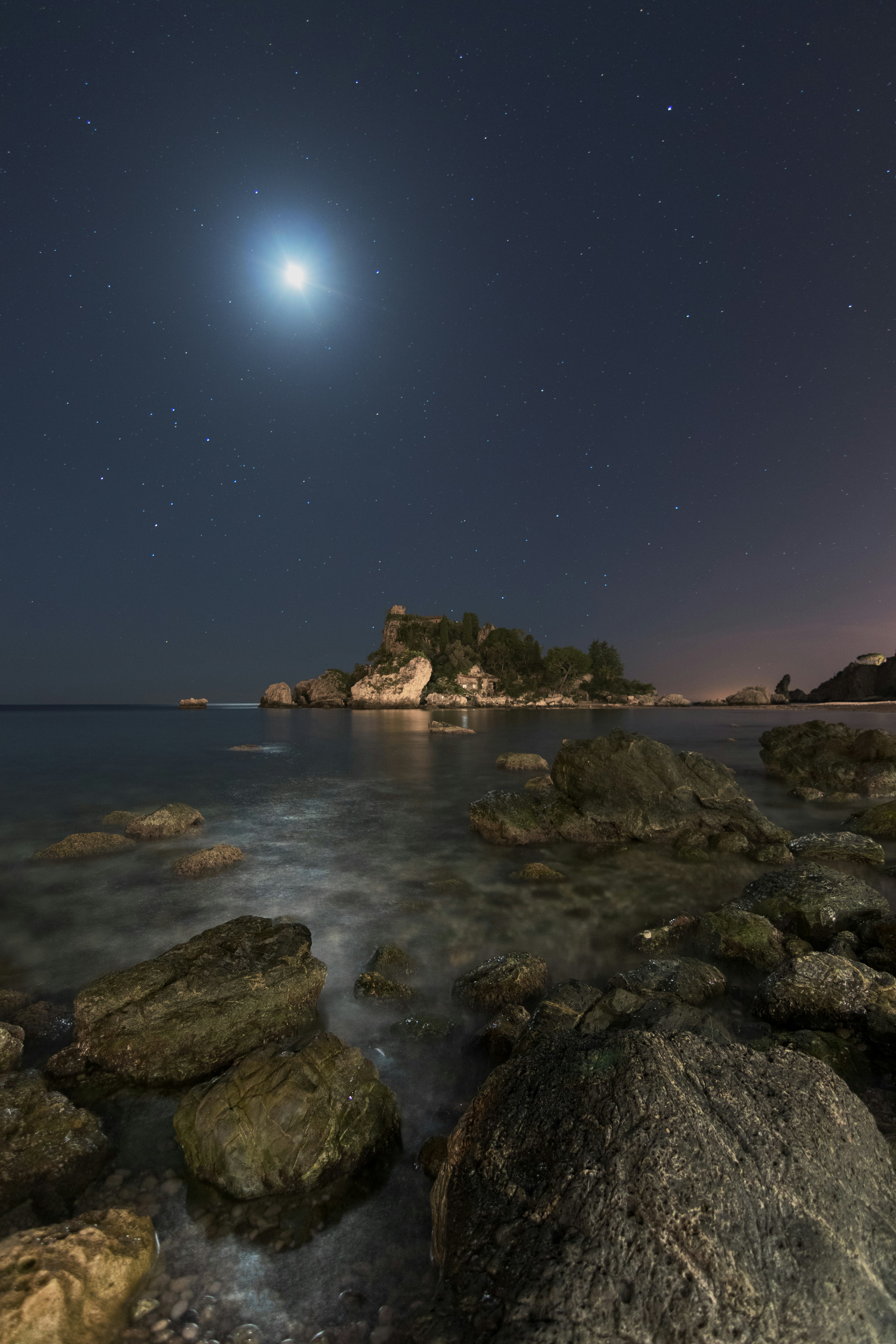 Moonlit Isle: Quiet Rocks Beneath a Starry Expanse