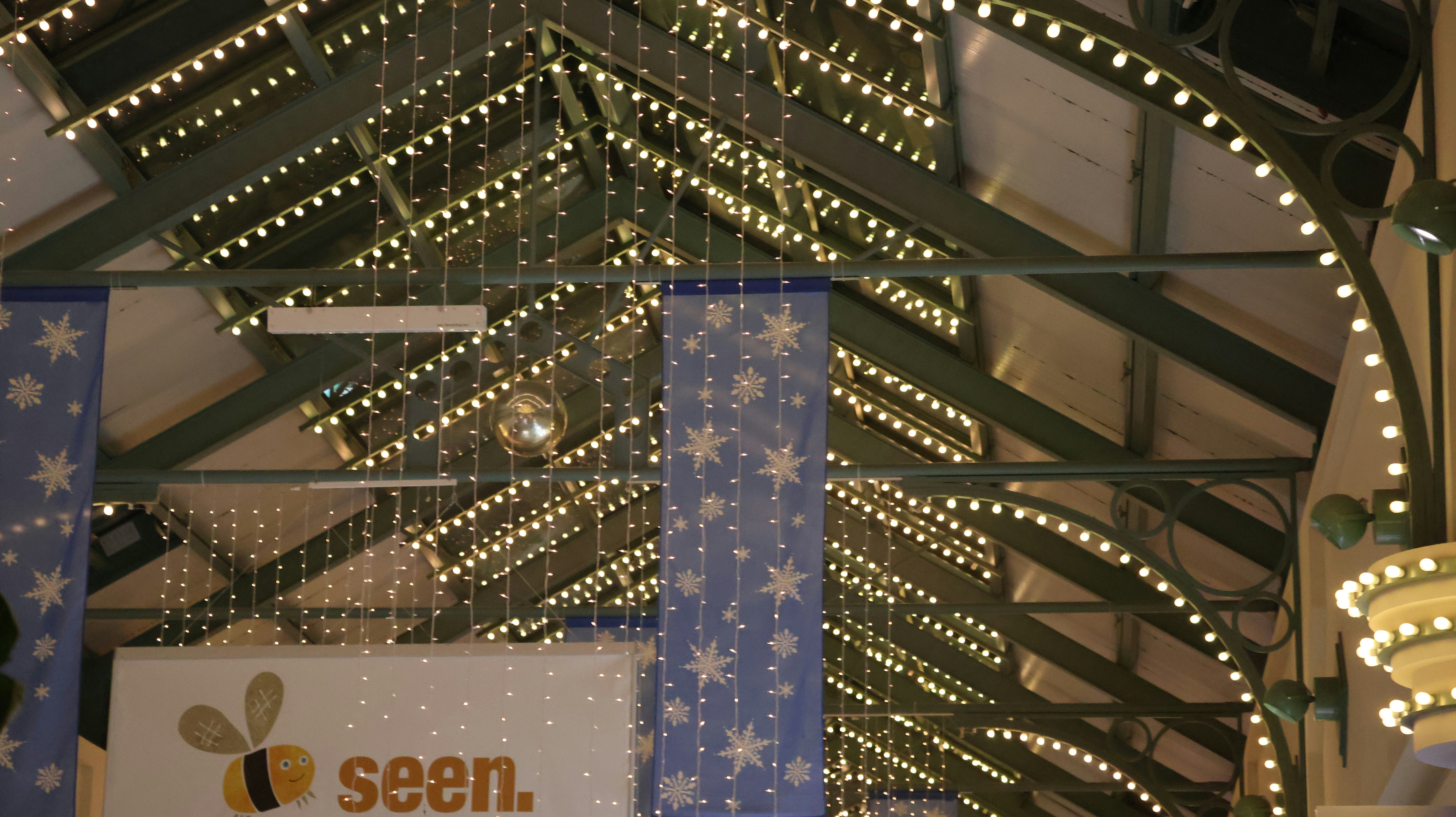 Stringed lights and star banners over a festive market entrance