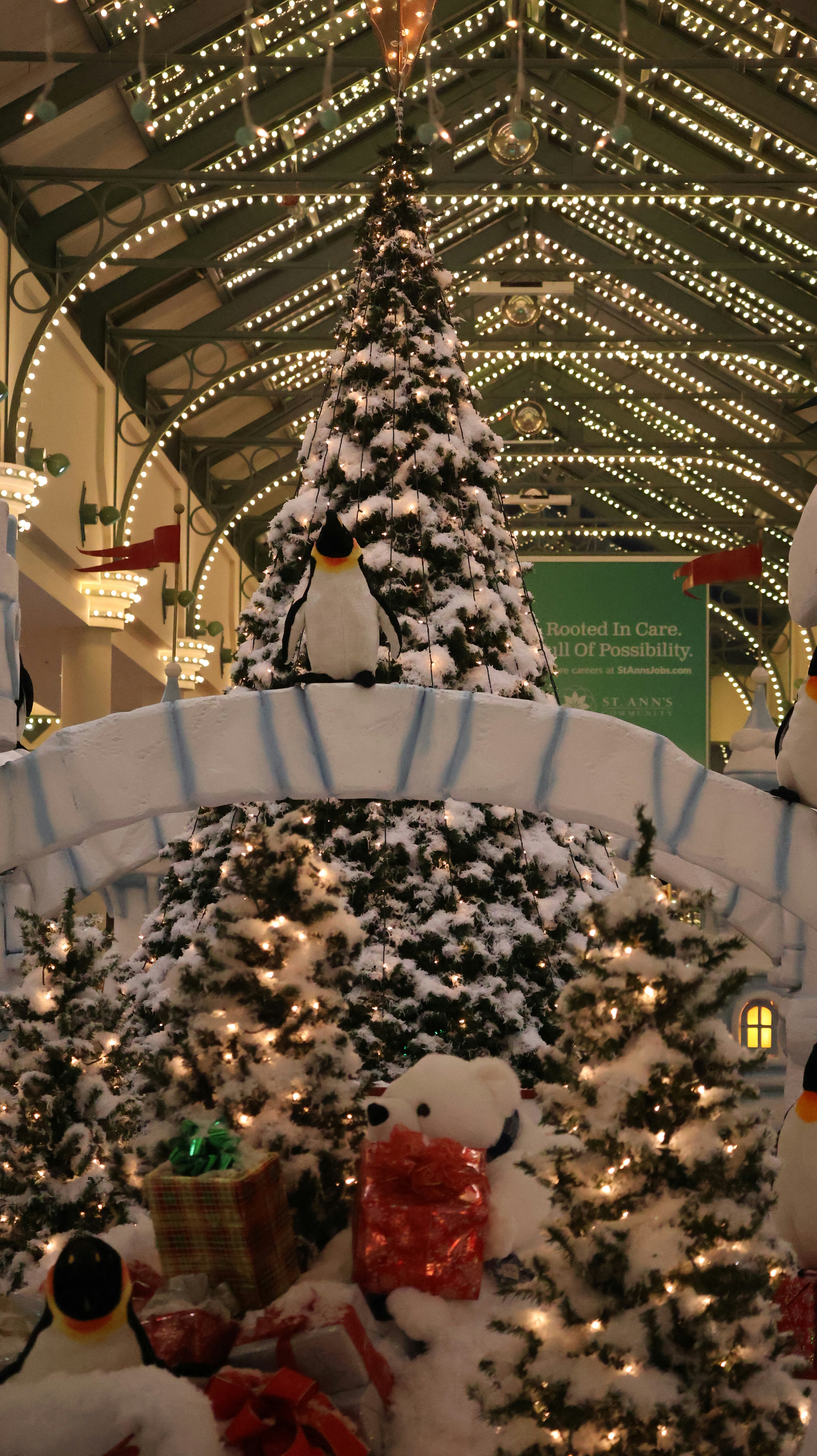 Penguin Attendant Amid Snow-Blanketed Christmas Tree