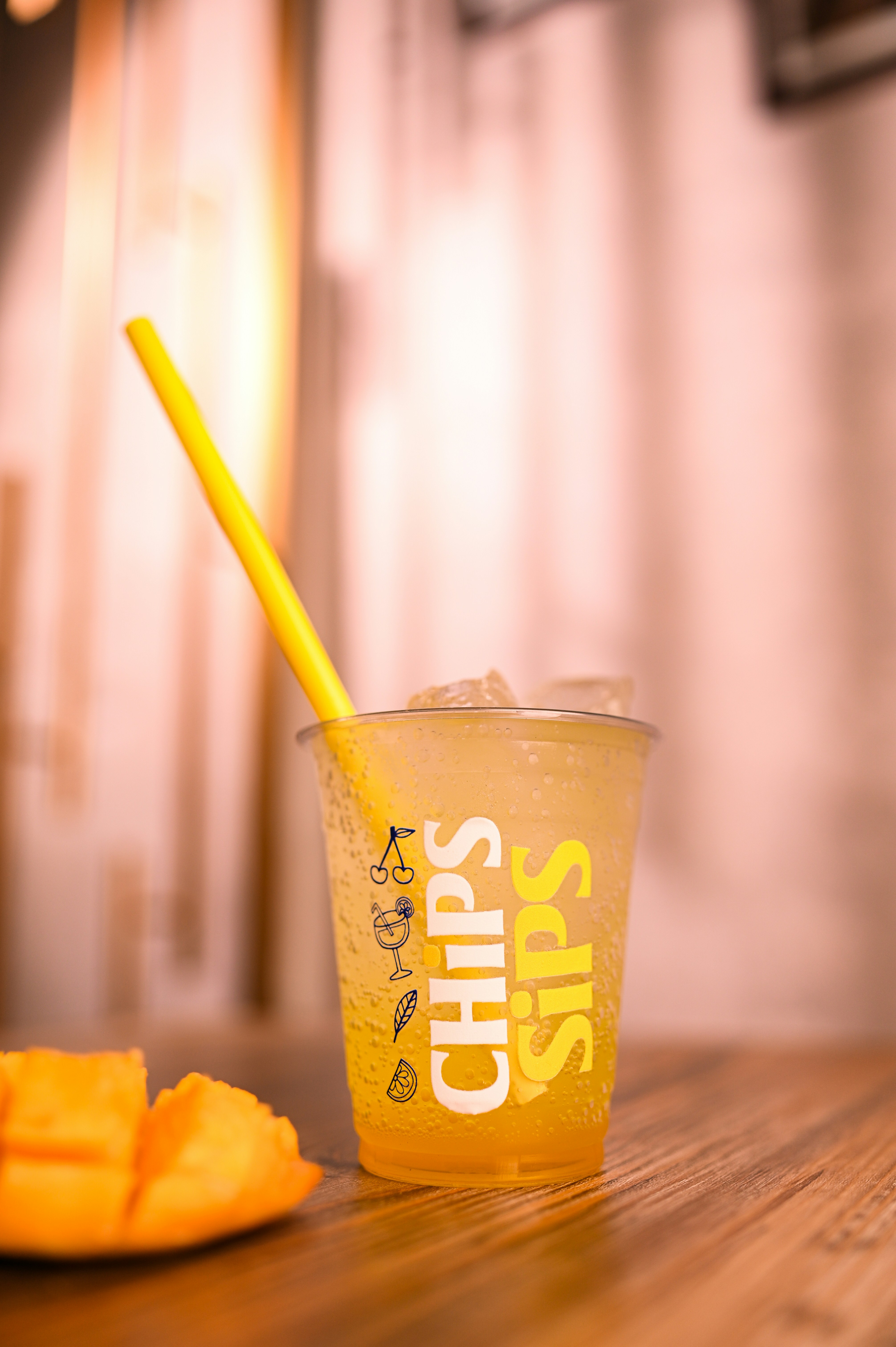 Citrus Glass with Striking Yellow Straw in Softly Blurred Scene