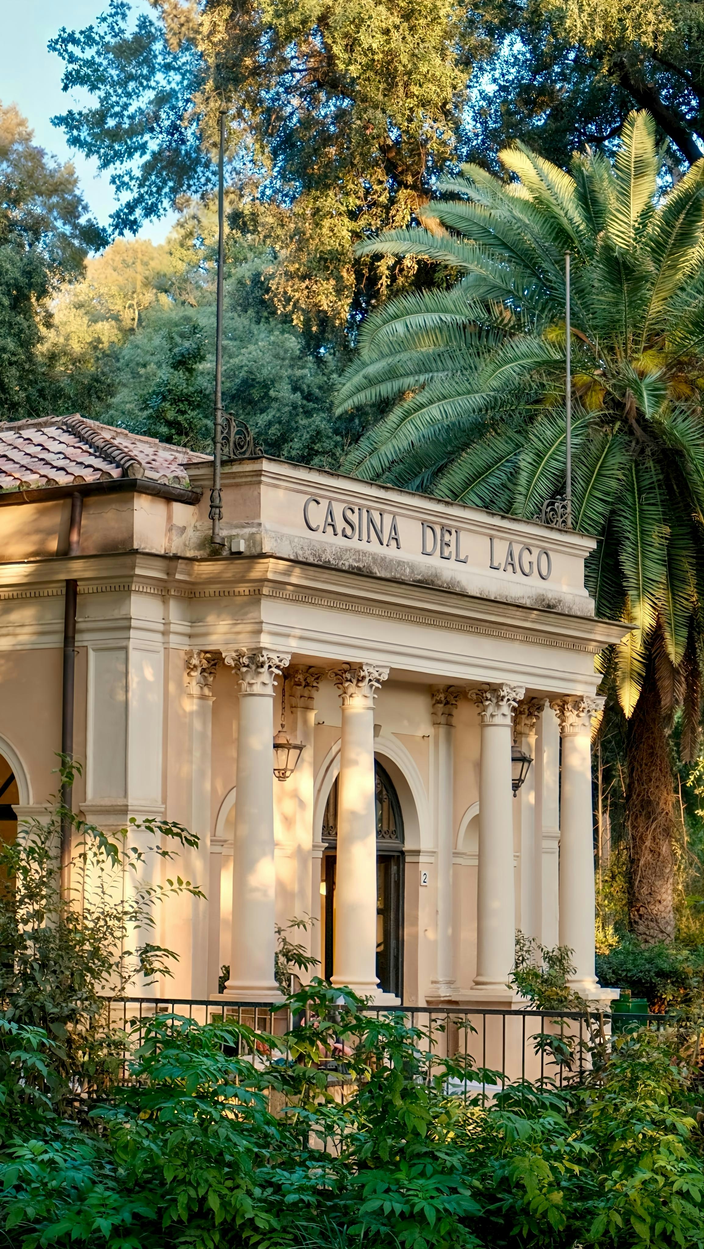 Casina Del Lago: A sunlit façade framed by palms and tiled roof