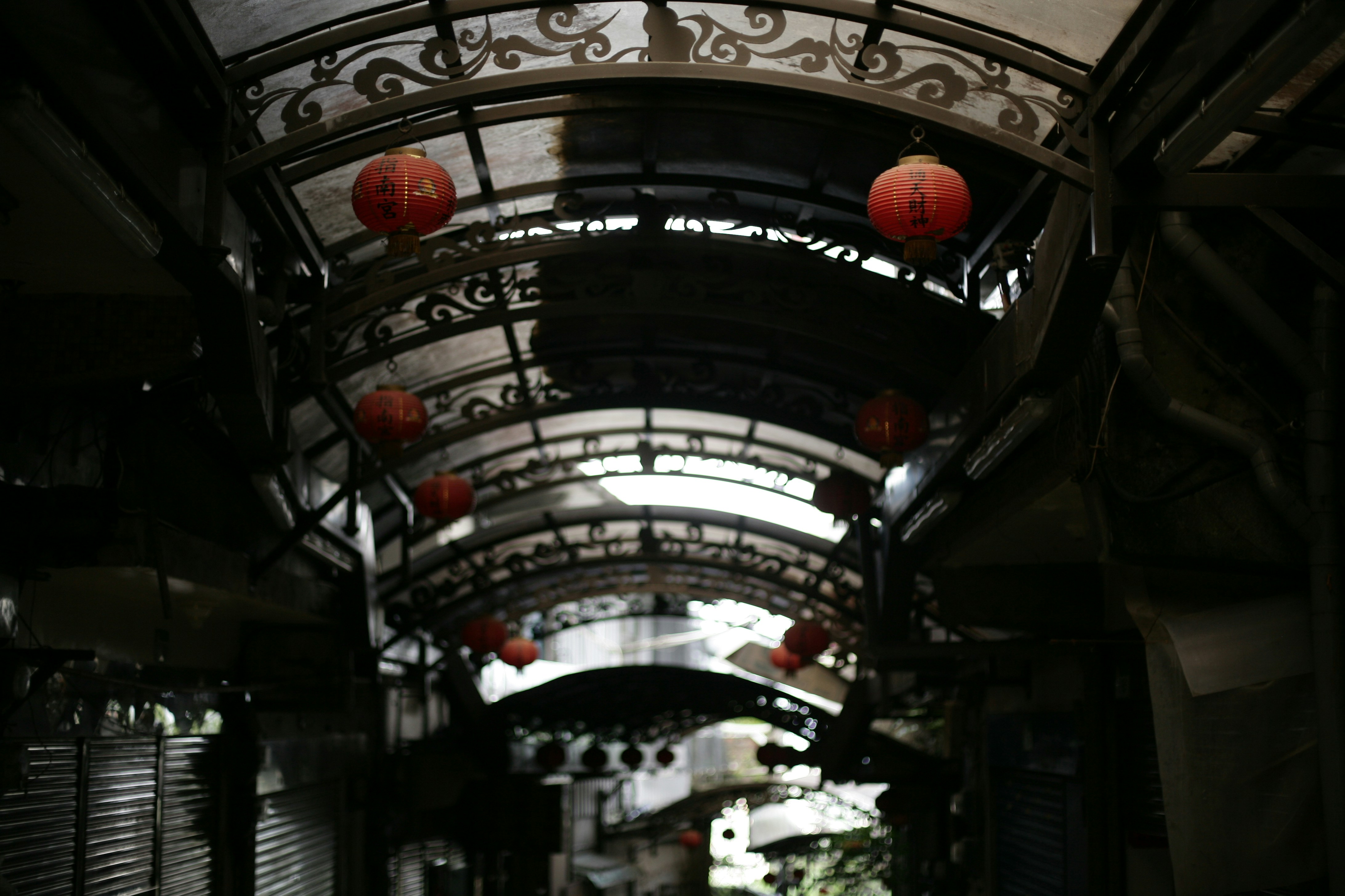 Red Lanterns along a Dimly Lit Archway Market Hall