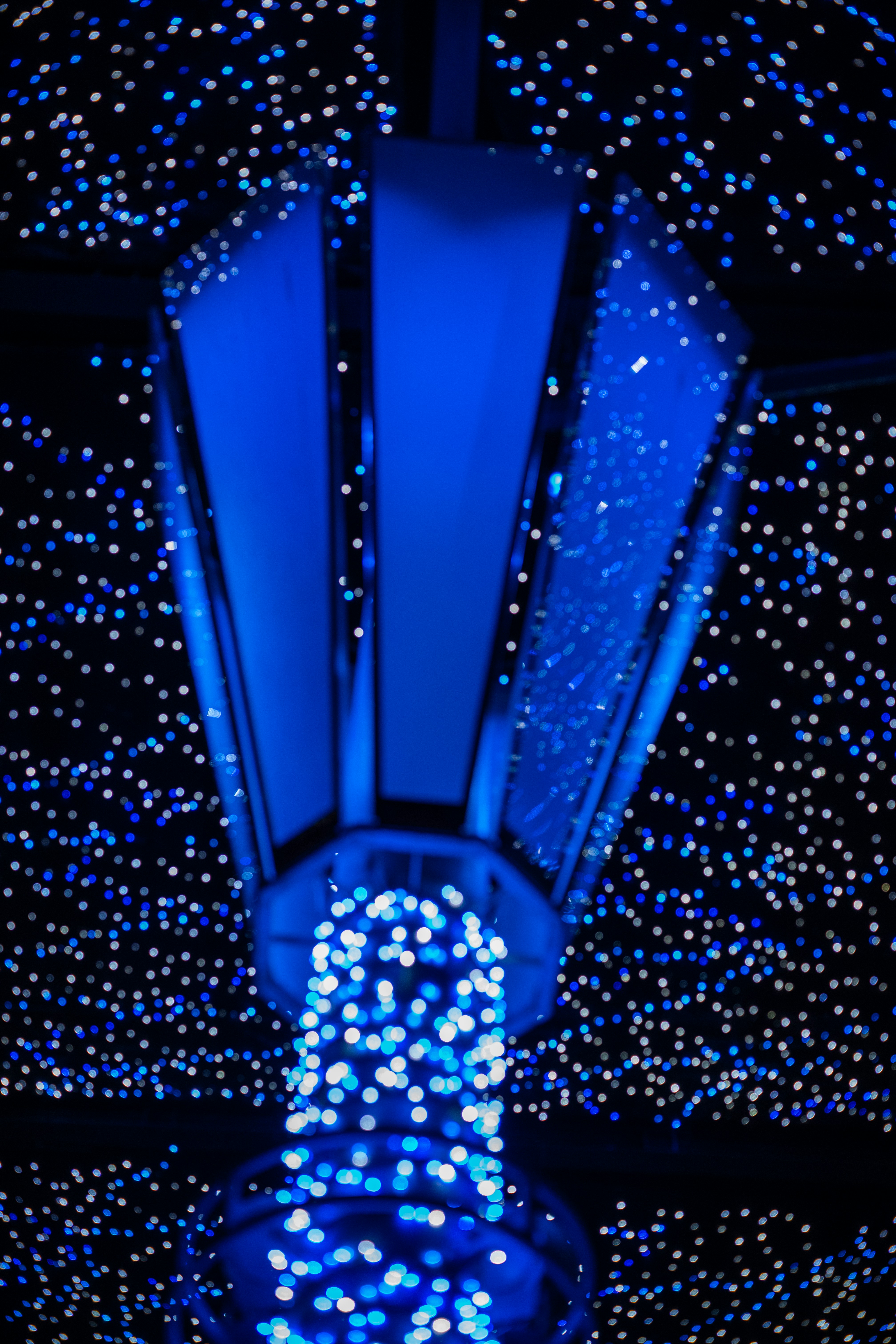 Blue lantern illuminated with blurred festive lights