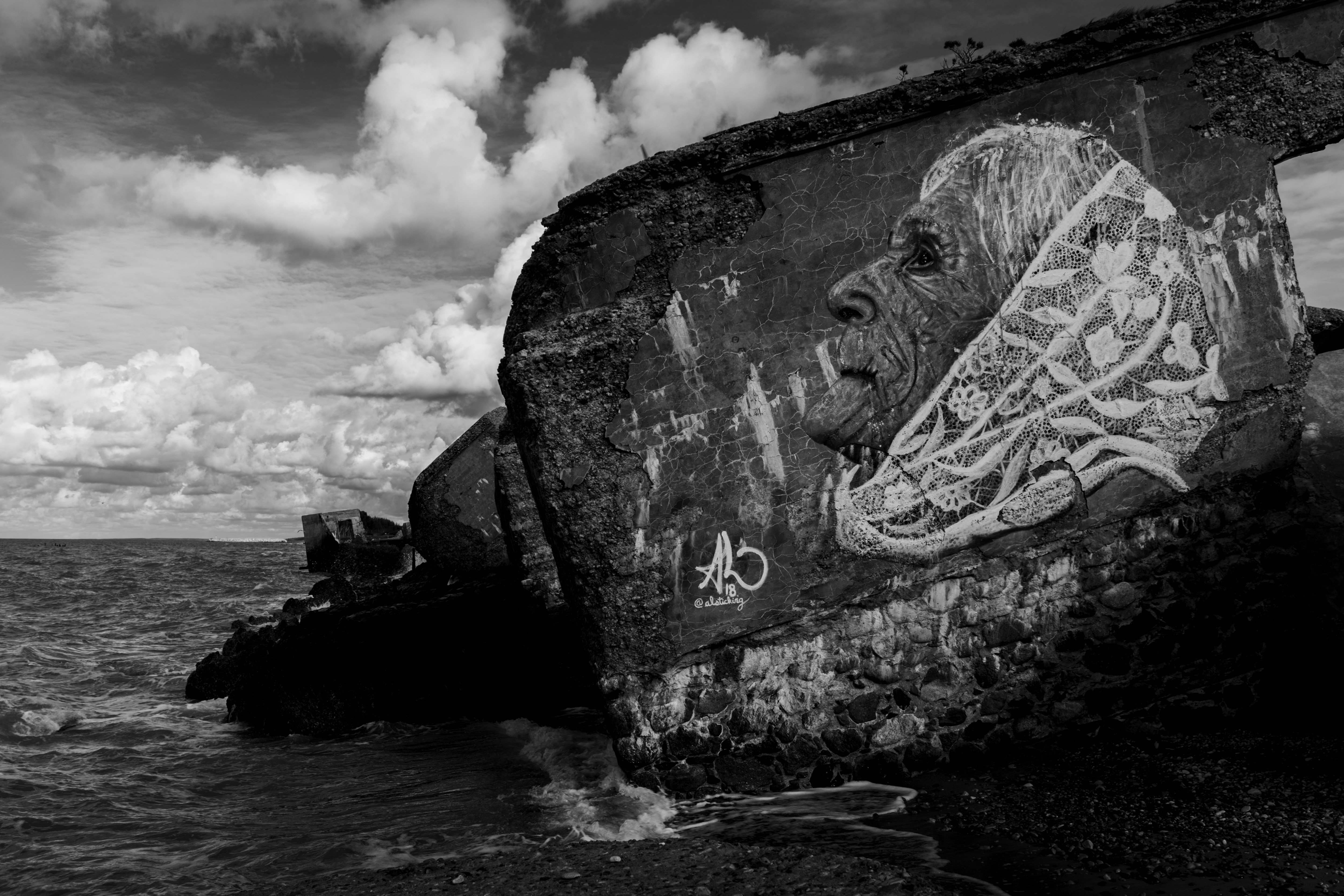 Grim Portrait: Graffiti Face Adrift on the Seaside Breakwater