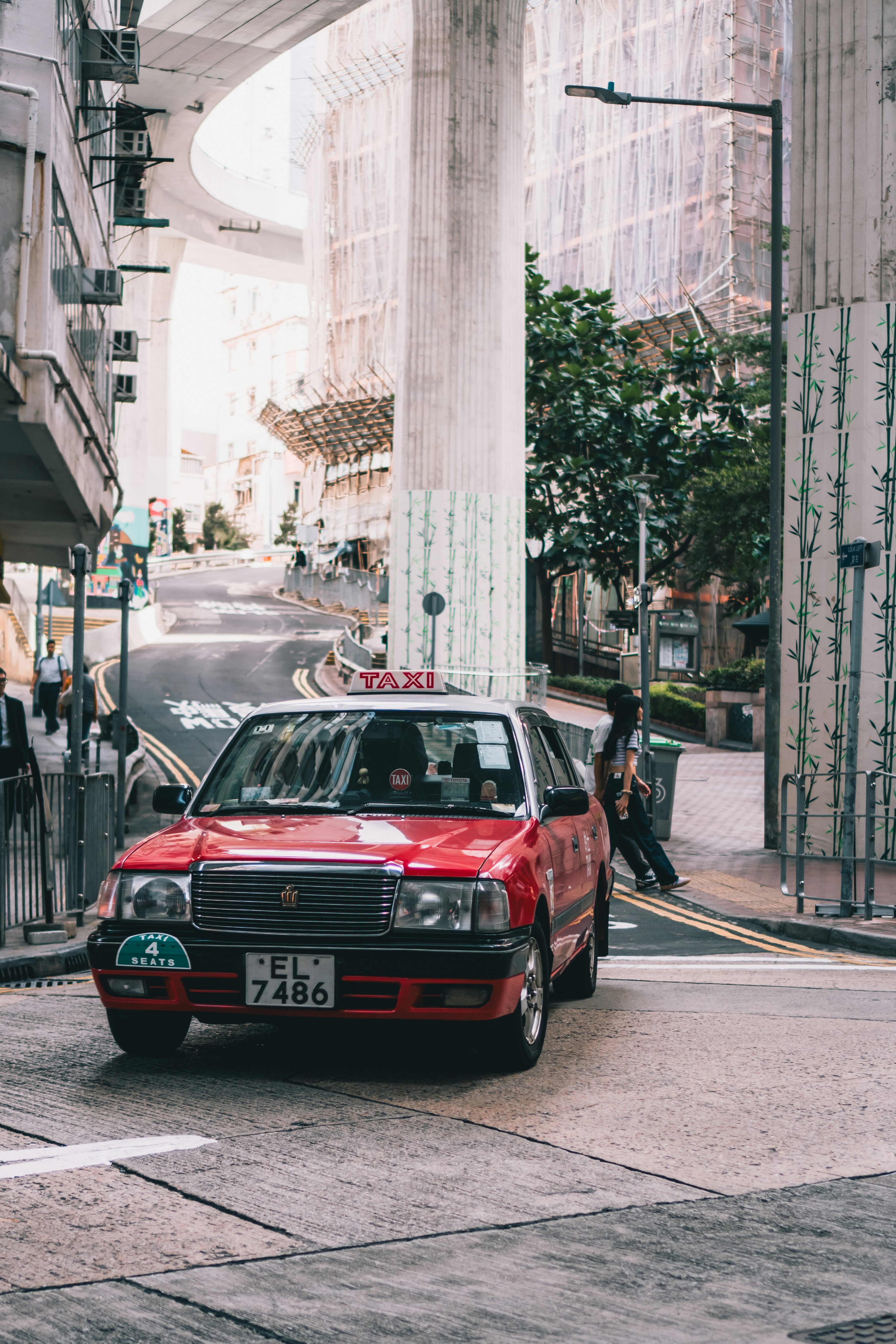 Red Taxi in an Urban Canyon under Elevated Tracks