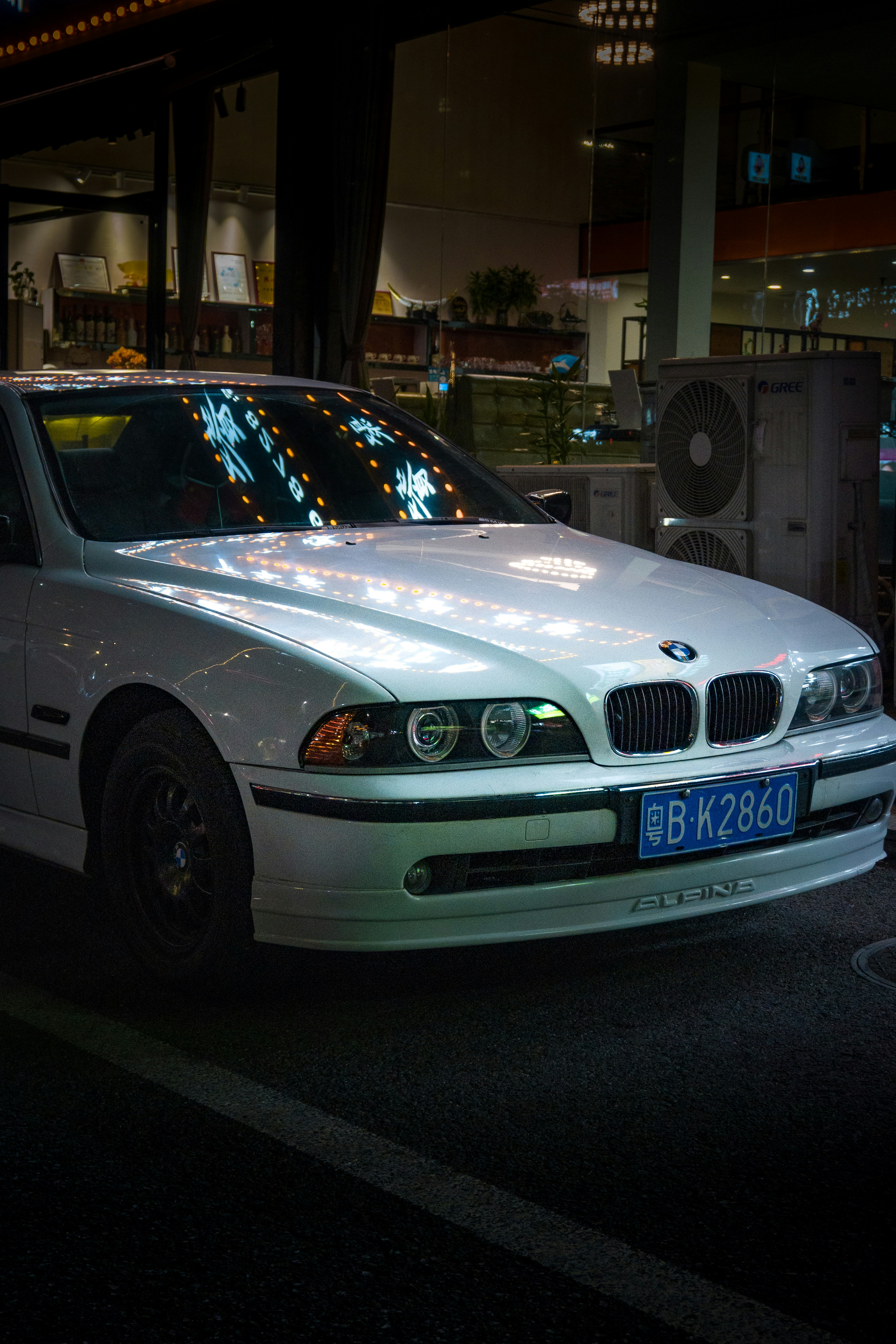 White BMW in Night Urban Scene with Neon Reflections