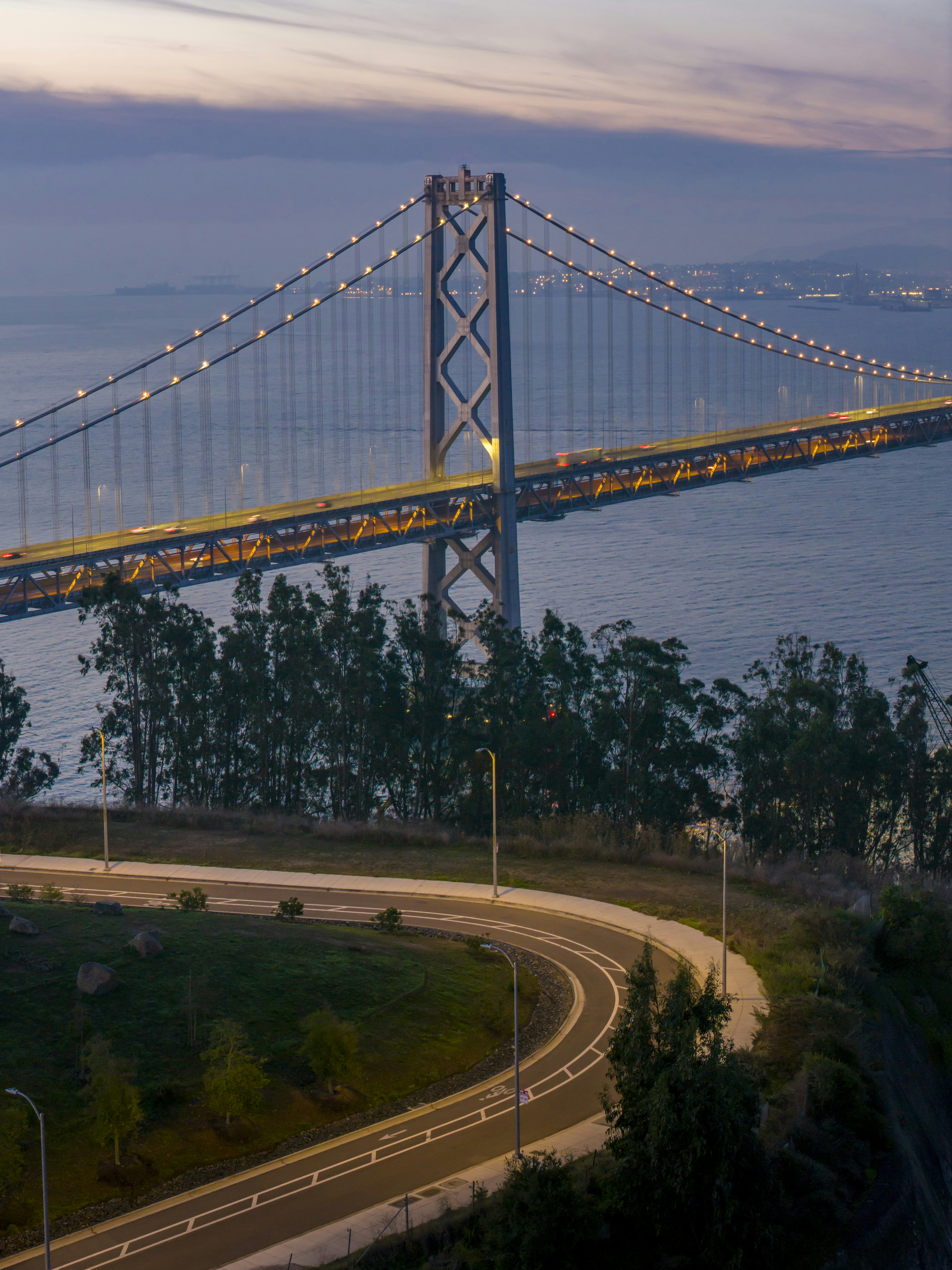 Suspended Dawn: A Coastal Bridge Span Rises Over Curving Road
