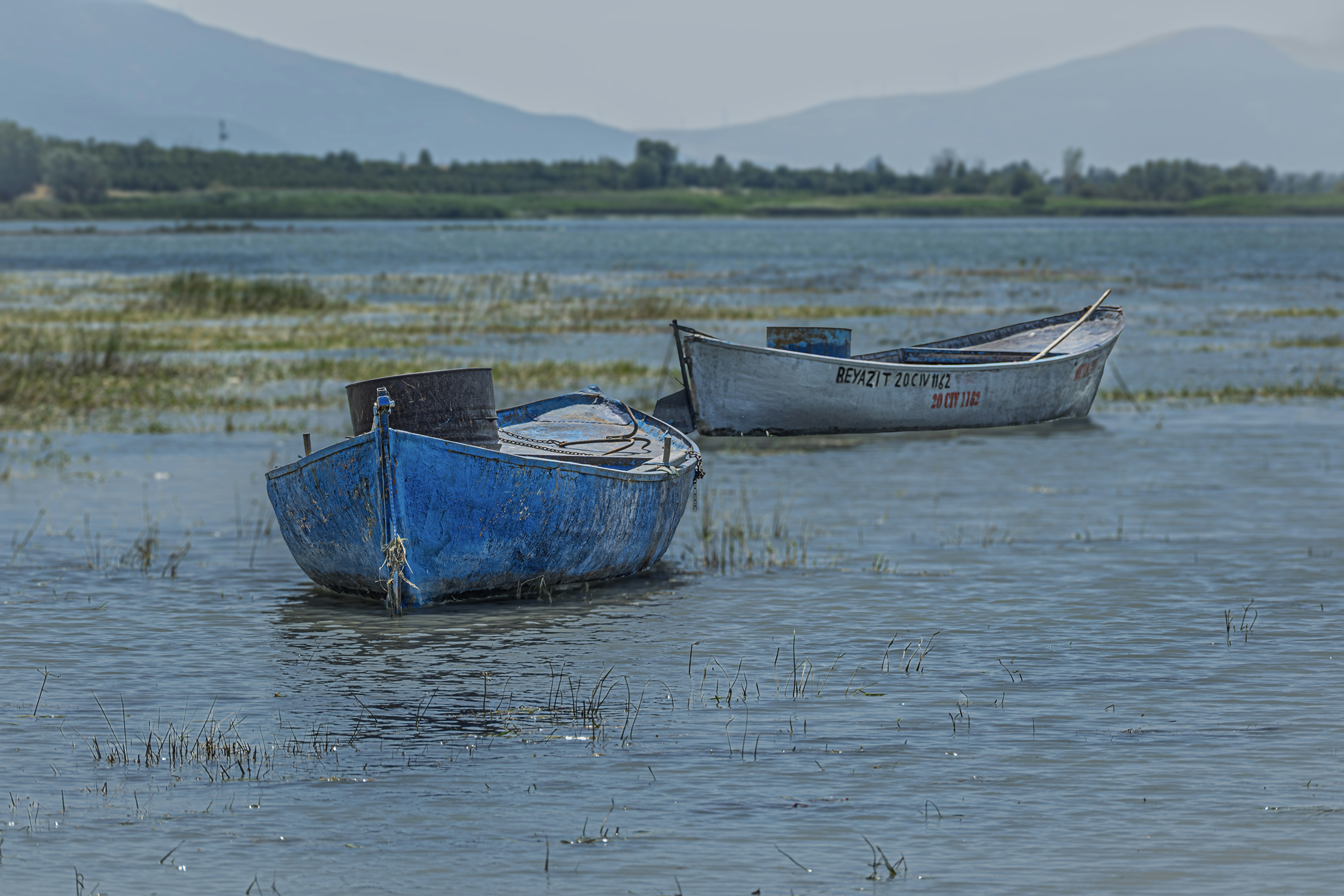 Blue boats resting on a tranquil tidal lagoon