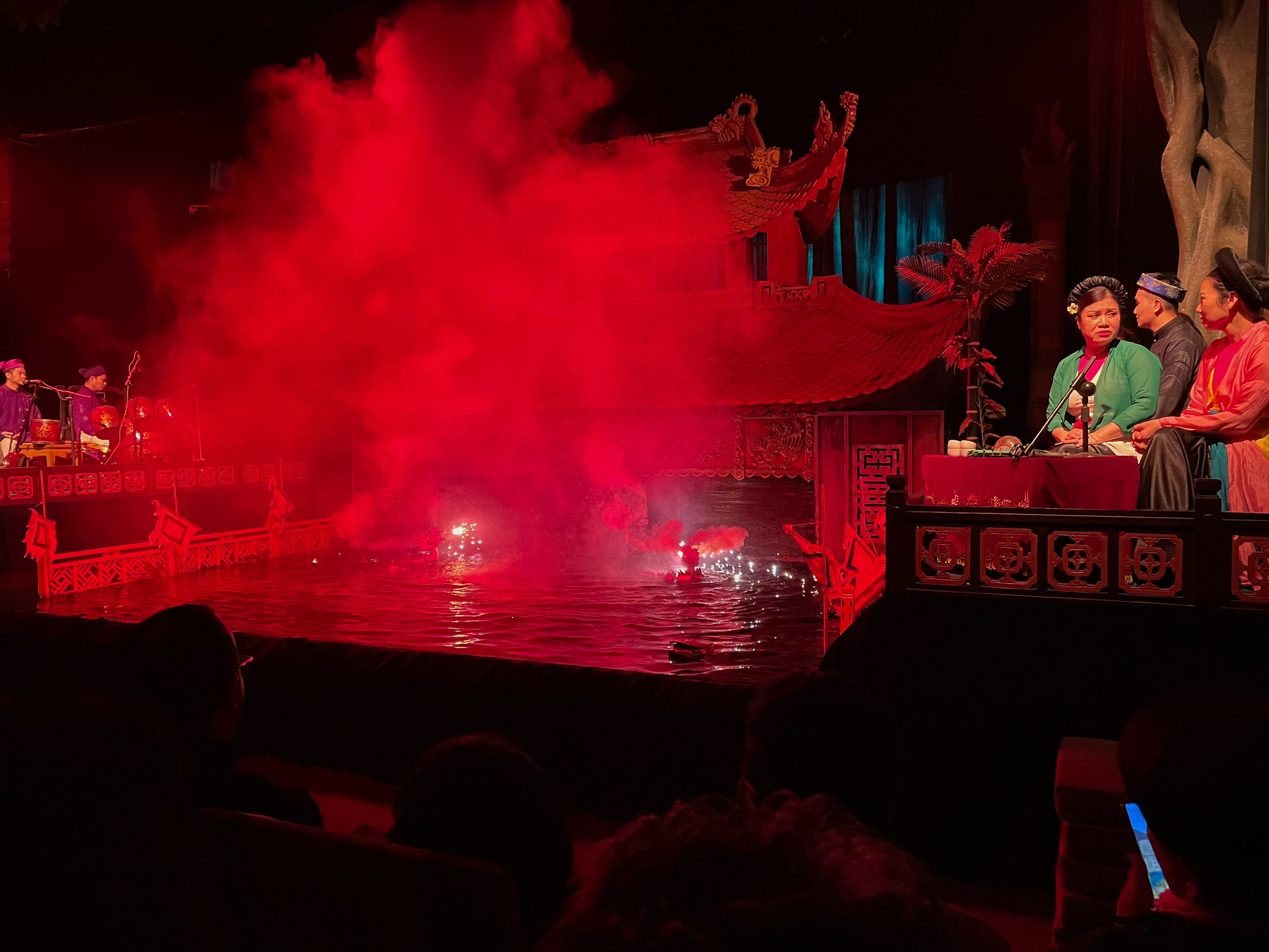People performing on a water stage with red smoke.Bernd 📷 Dittrich
