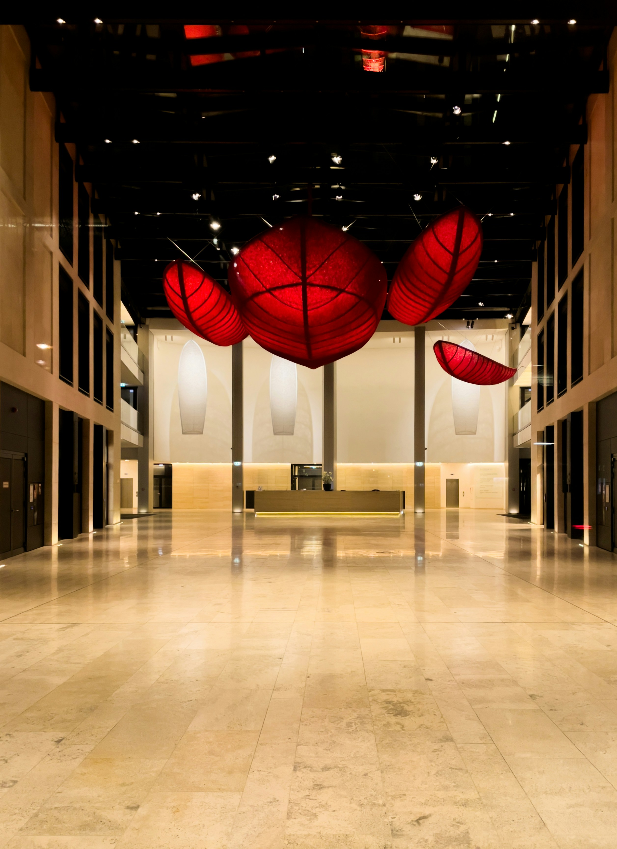 Red Sphere Ballet: Suspended Orbs Over a Quiet Lobby