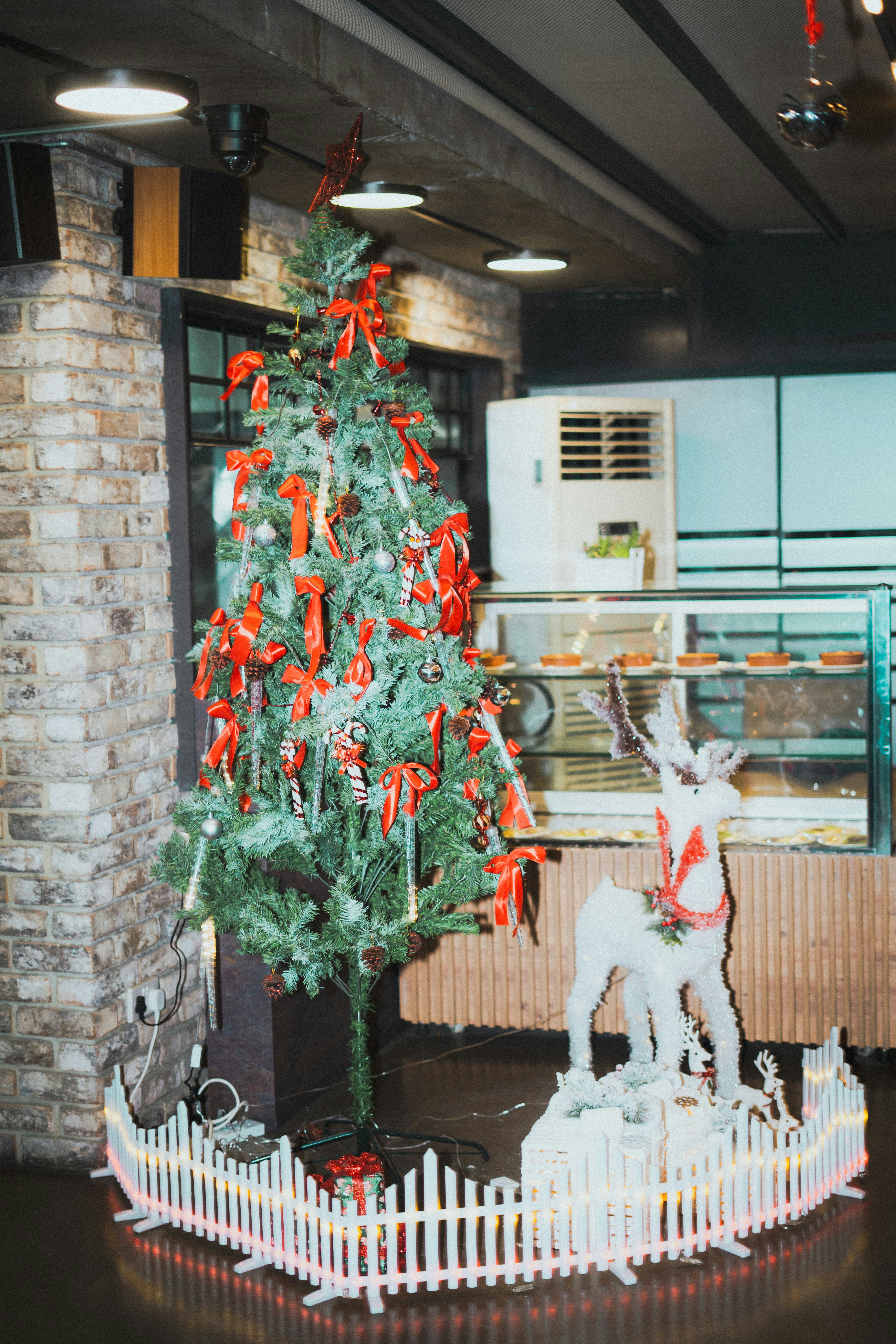 Festive Spark: A Christmas Corner with Tree, Reindeer, and Pastry Display