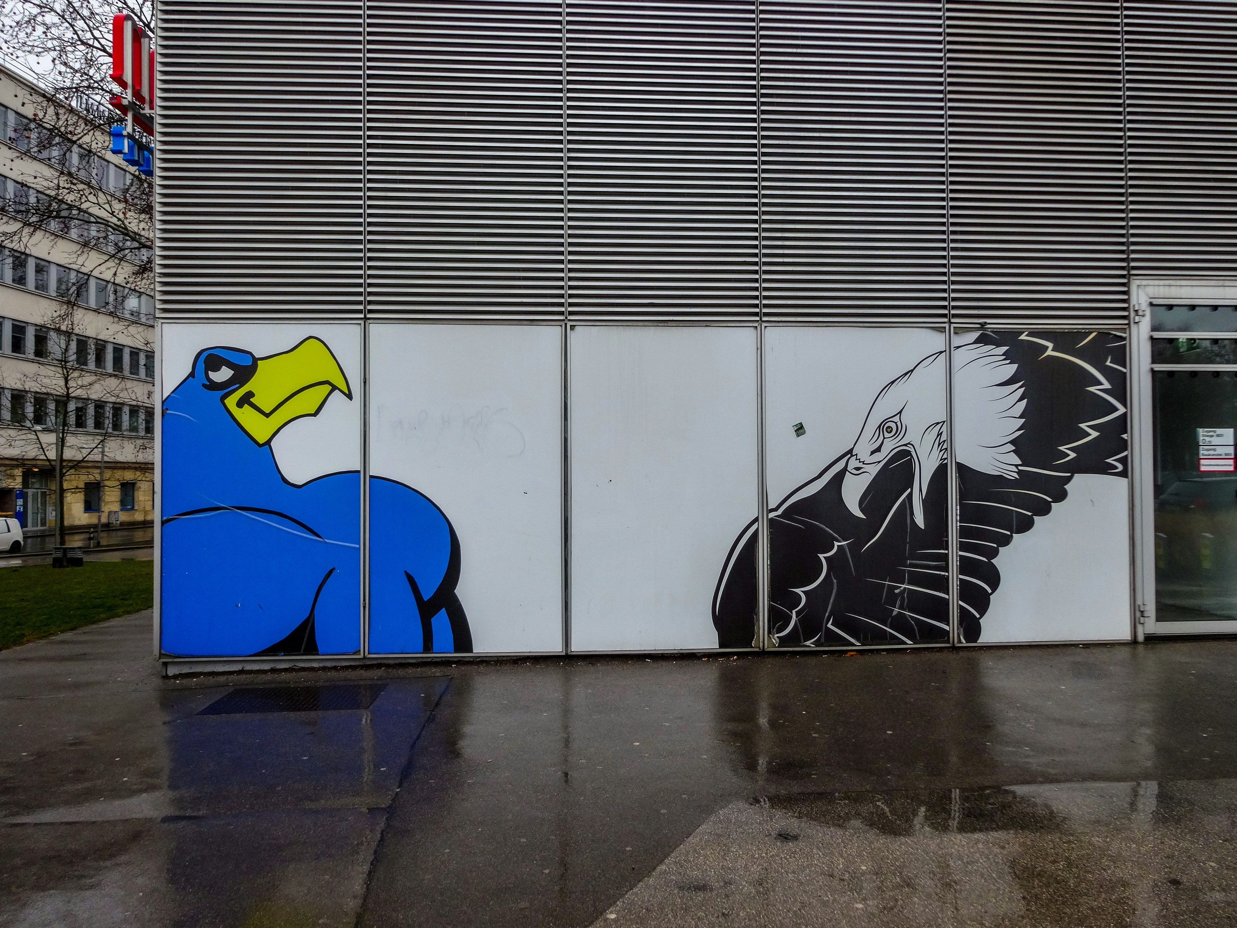 Blue bird cartoon and eagle wing mural on building