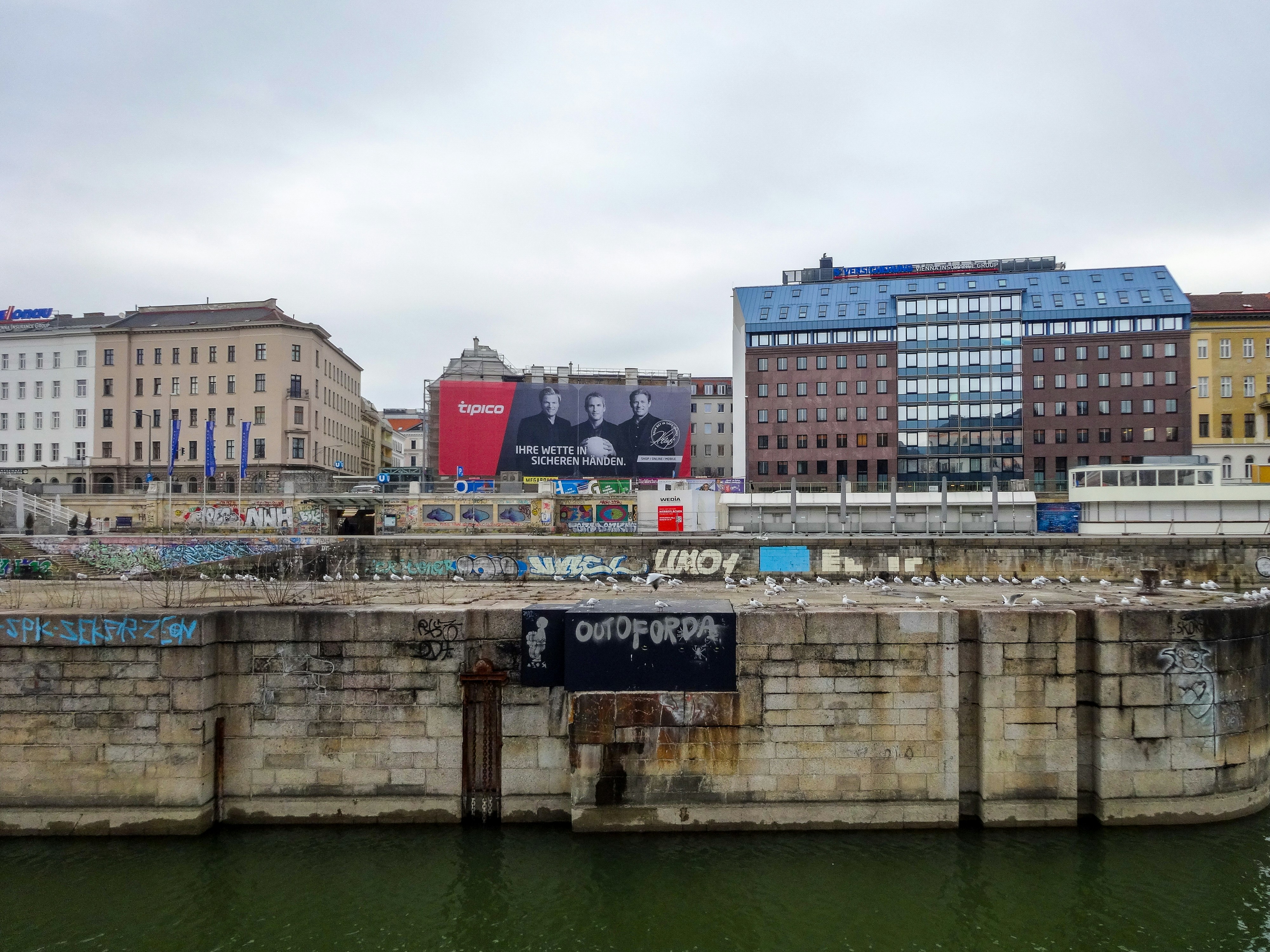 Riverside Façade: A Quiet City Wake Between Bridges and Billboards