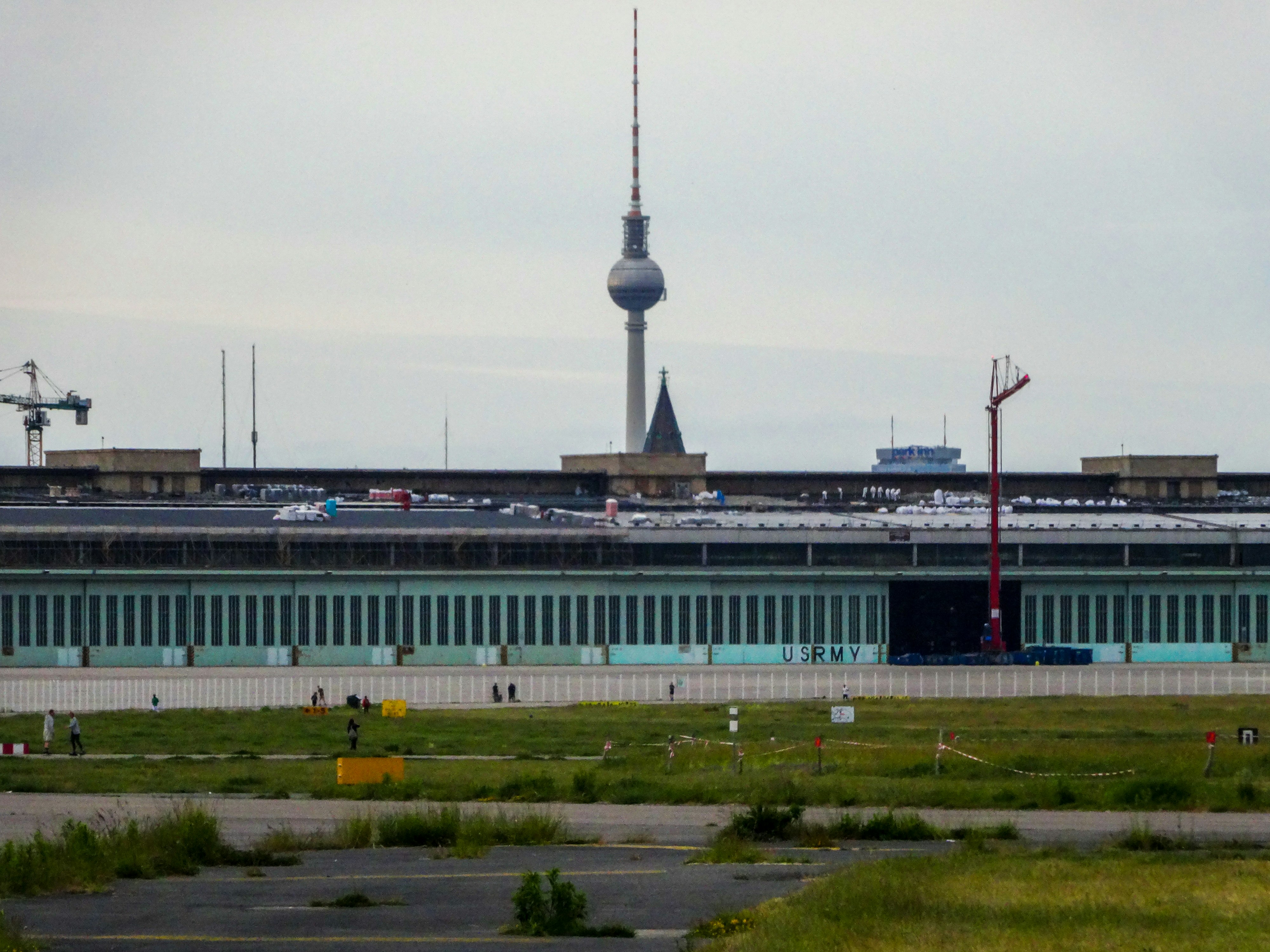 Modern airport building with TV tower in background.