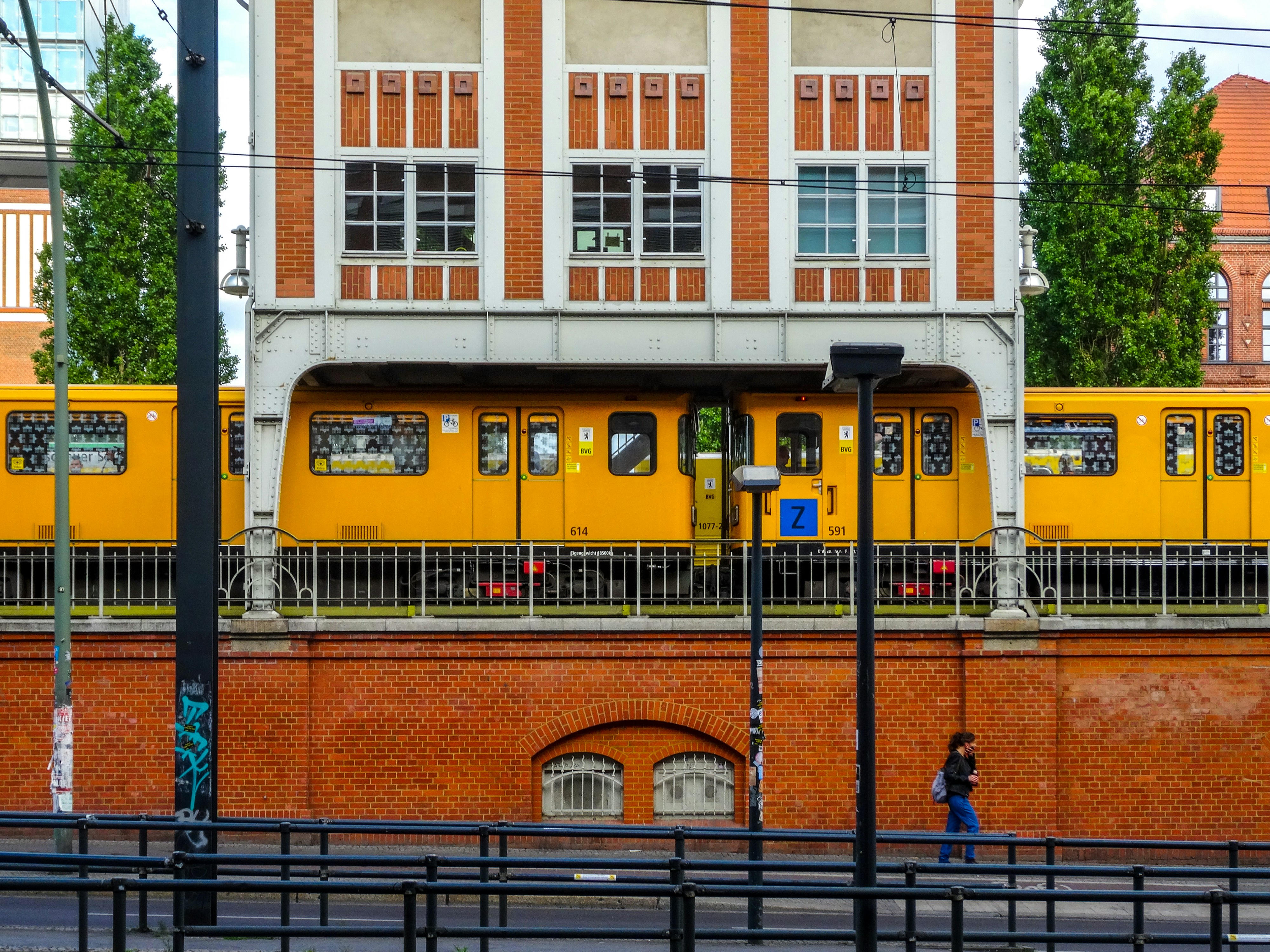 Brick Bridge Transit: A Yellow Train Under Urban Archways