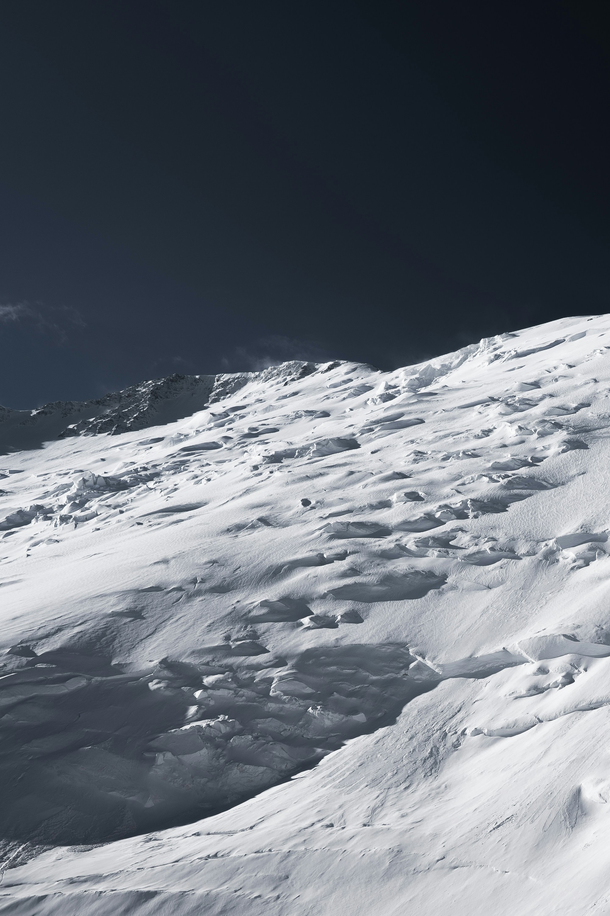 Snowy mountain slope under dark sky photo – Free Winter Image on Unsplash