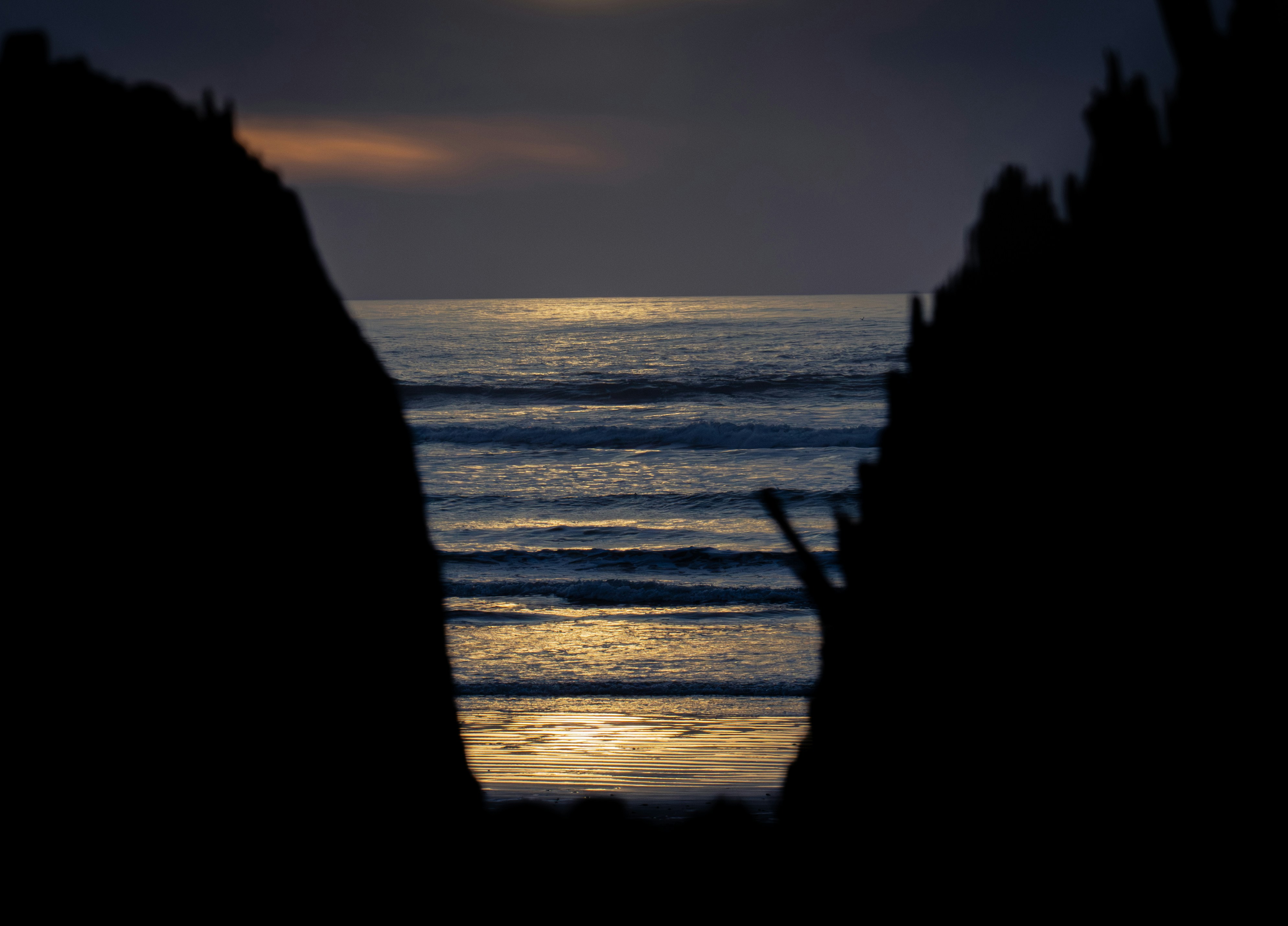 Silhouette Between Waves: Sunset Gap Between Cliffs