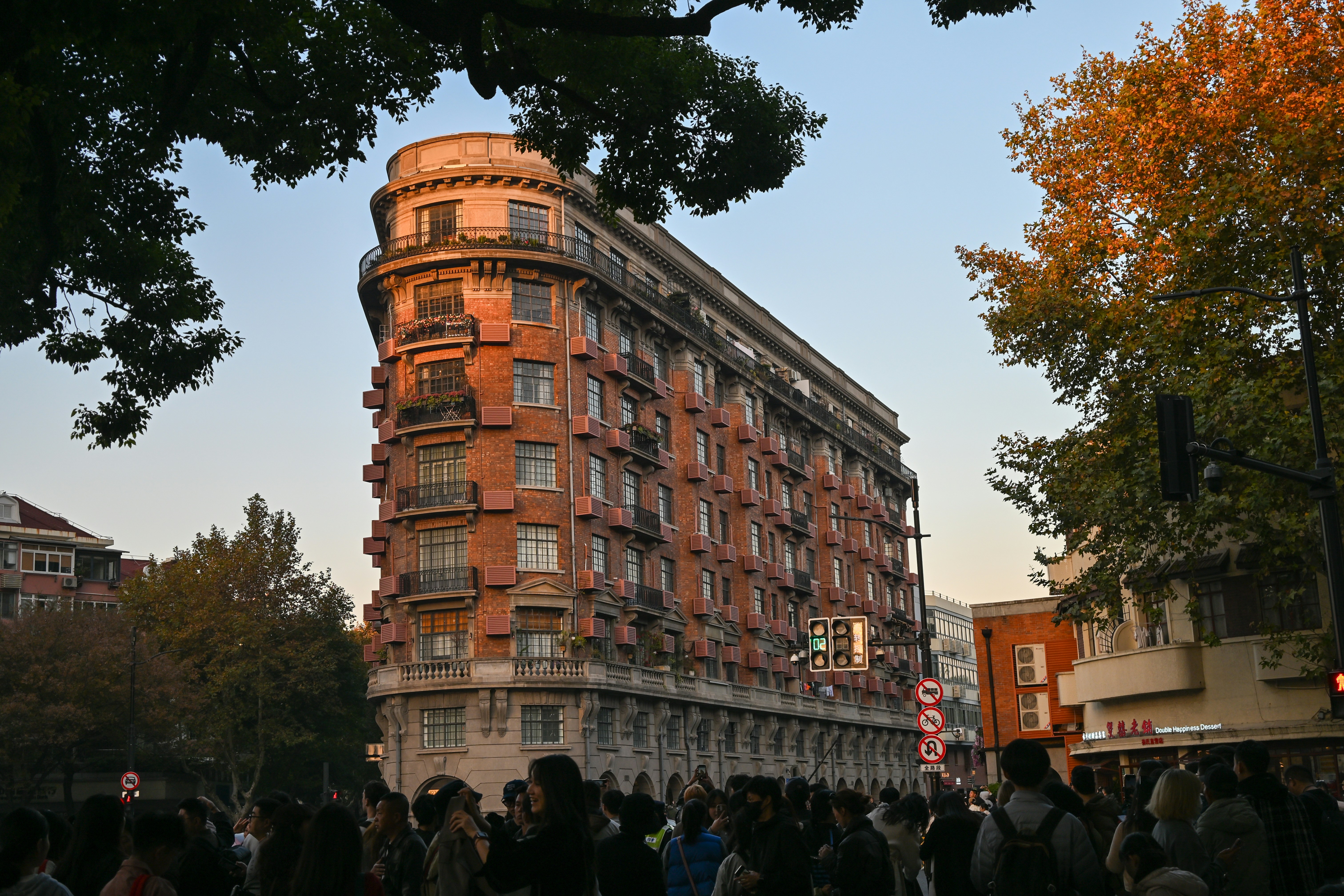 Sunlit Historic Corner: A Busy Street Framed by a Rounded Brick Facade
