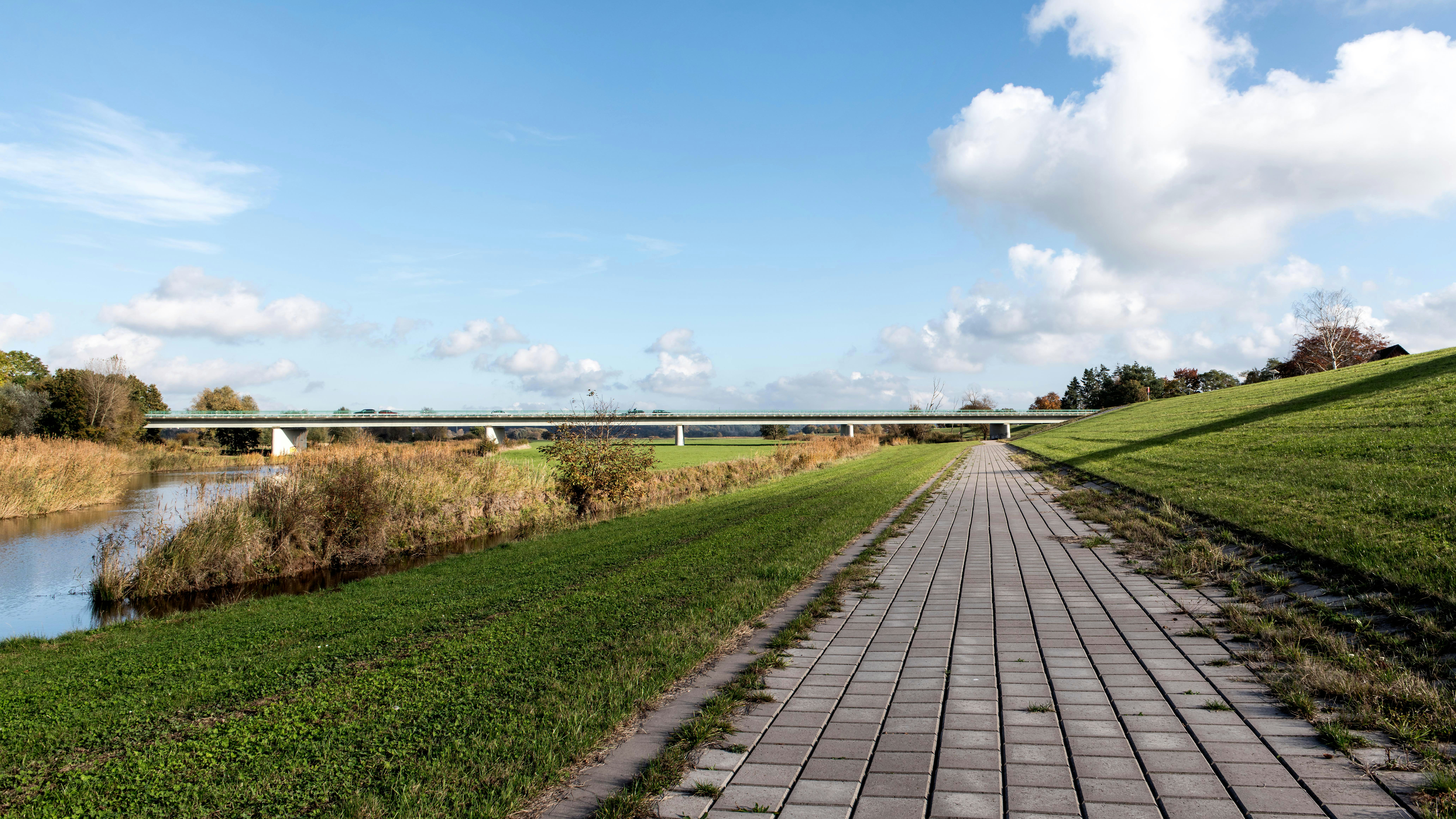 Riverside Promenade: A Concrete Path Reaches Toward a Distant Bridge