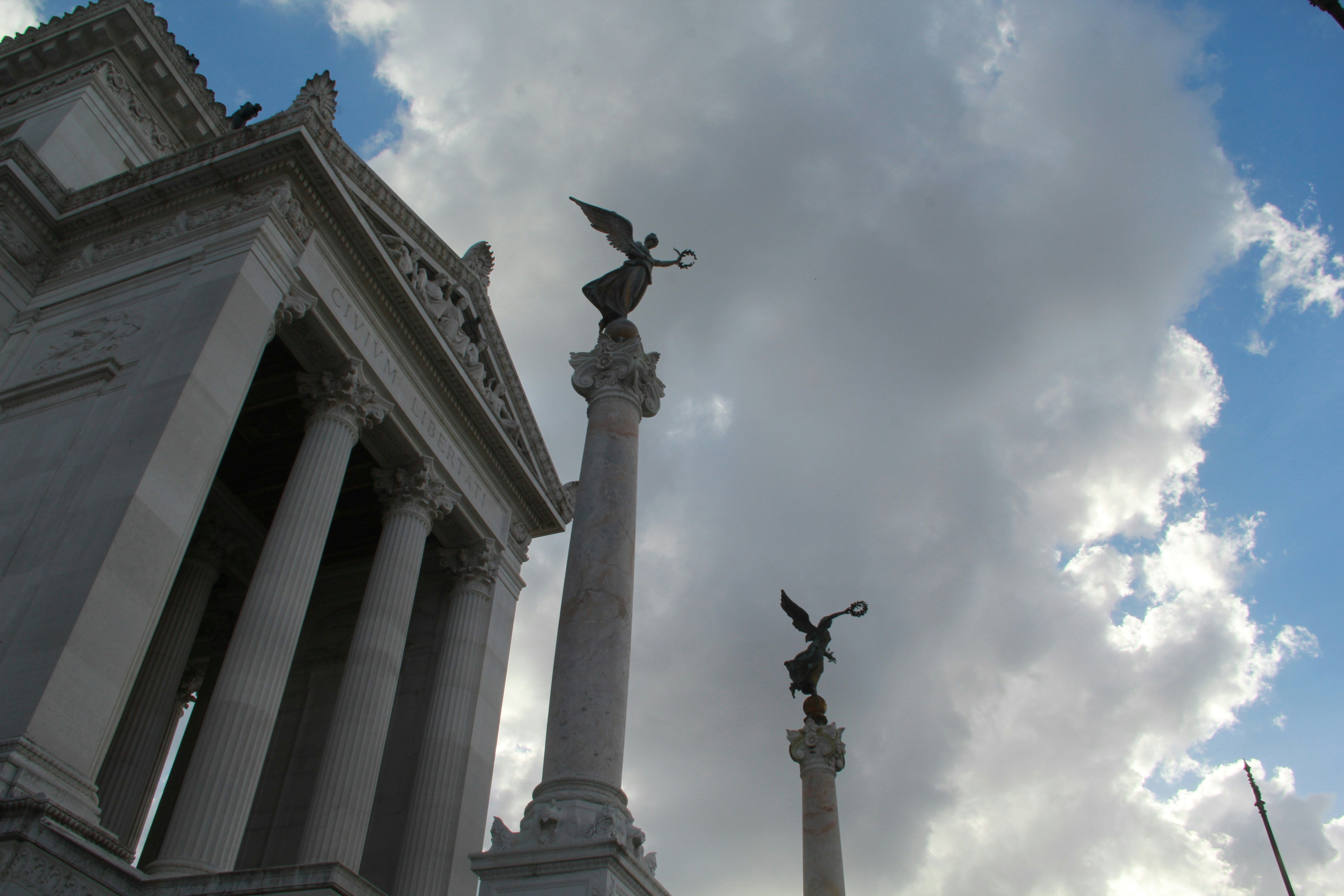 Statues atop a classical triumph: angels guarding the neoclassical façade